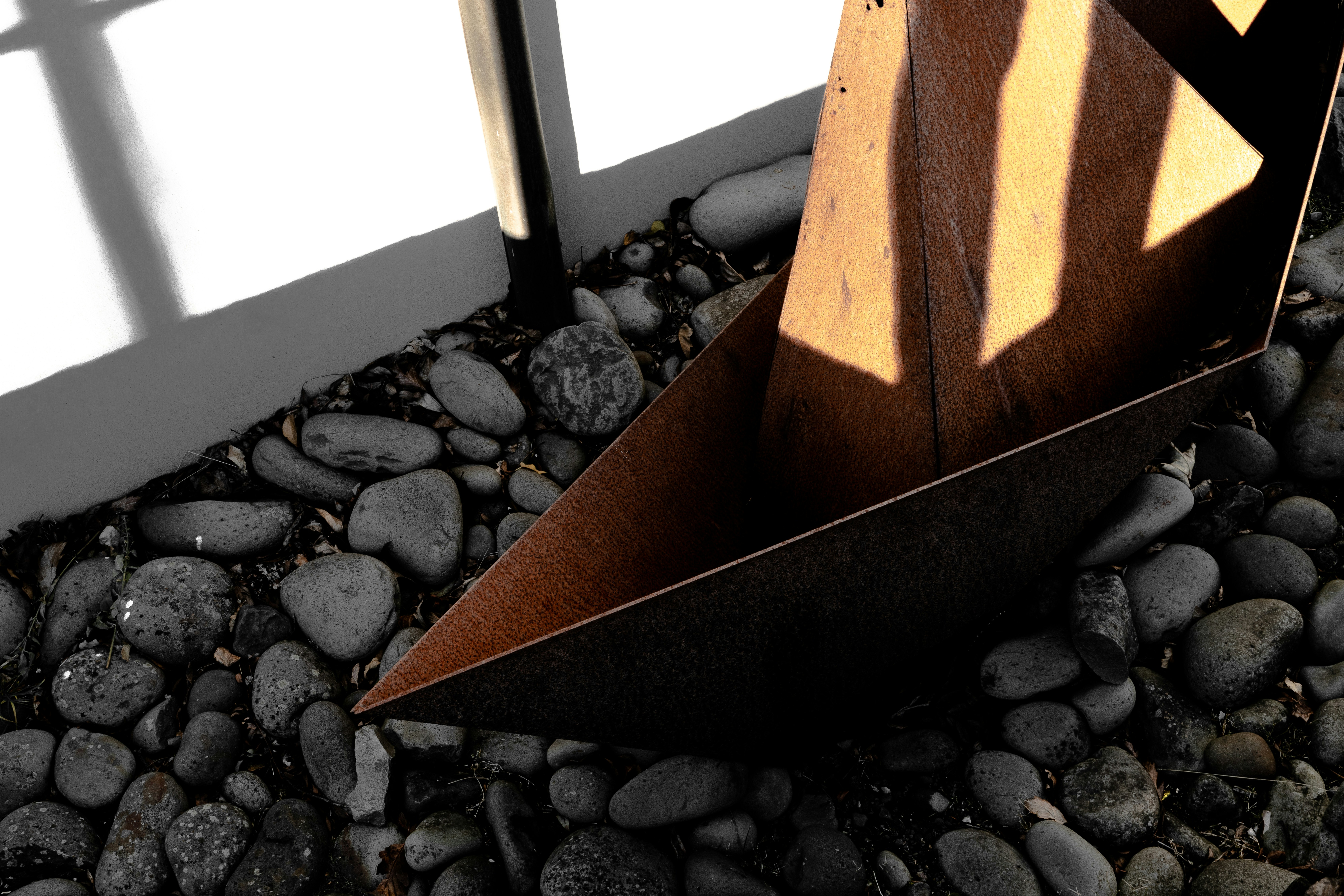 Rusted Geometry Among River Rocks