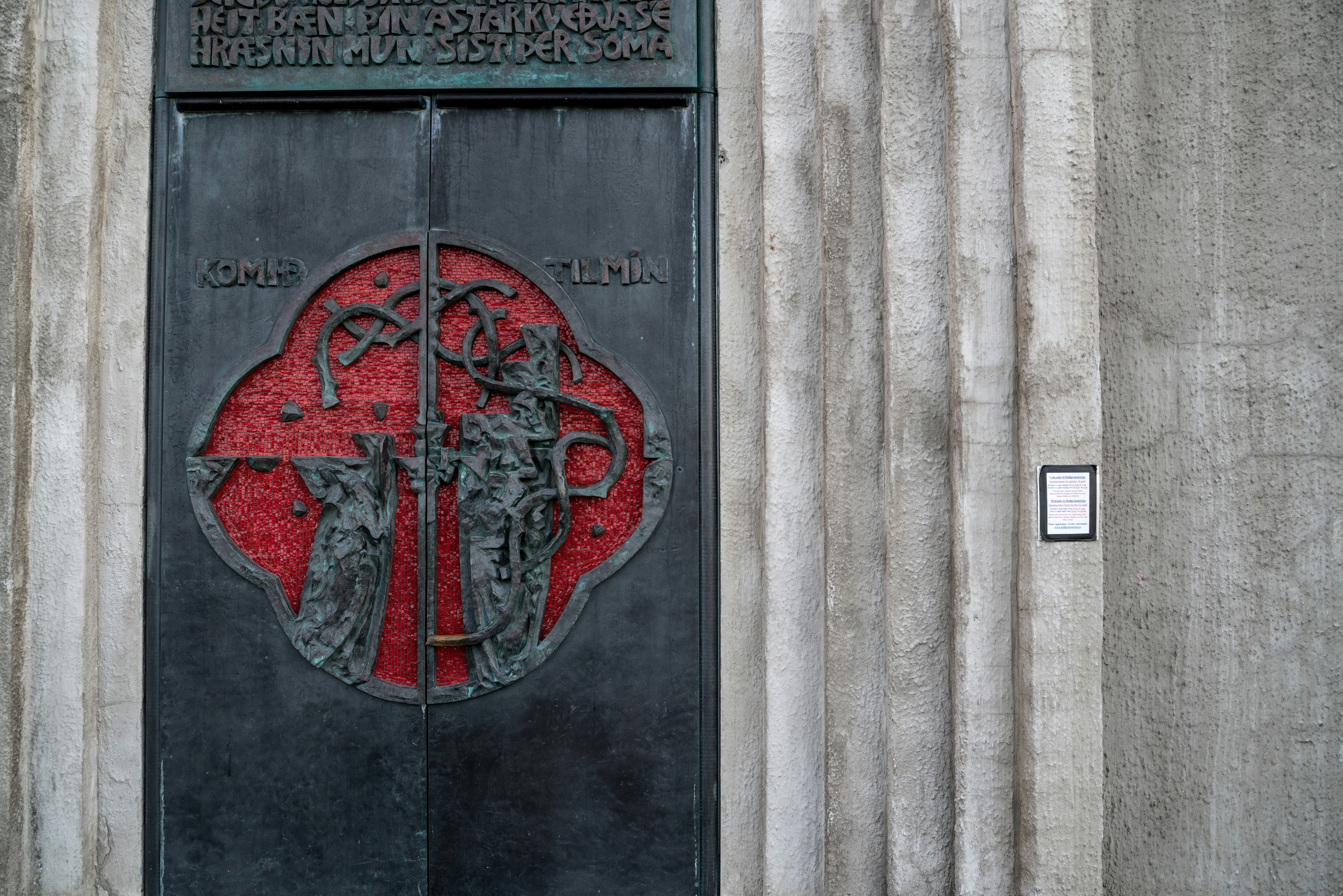Red Gate of Silence: A Concrete Facade Framed by Steel Slabs