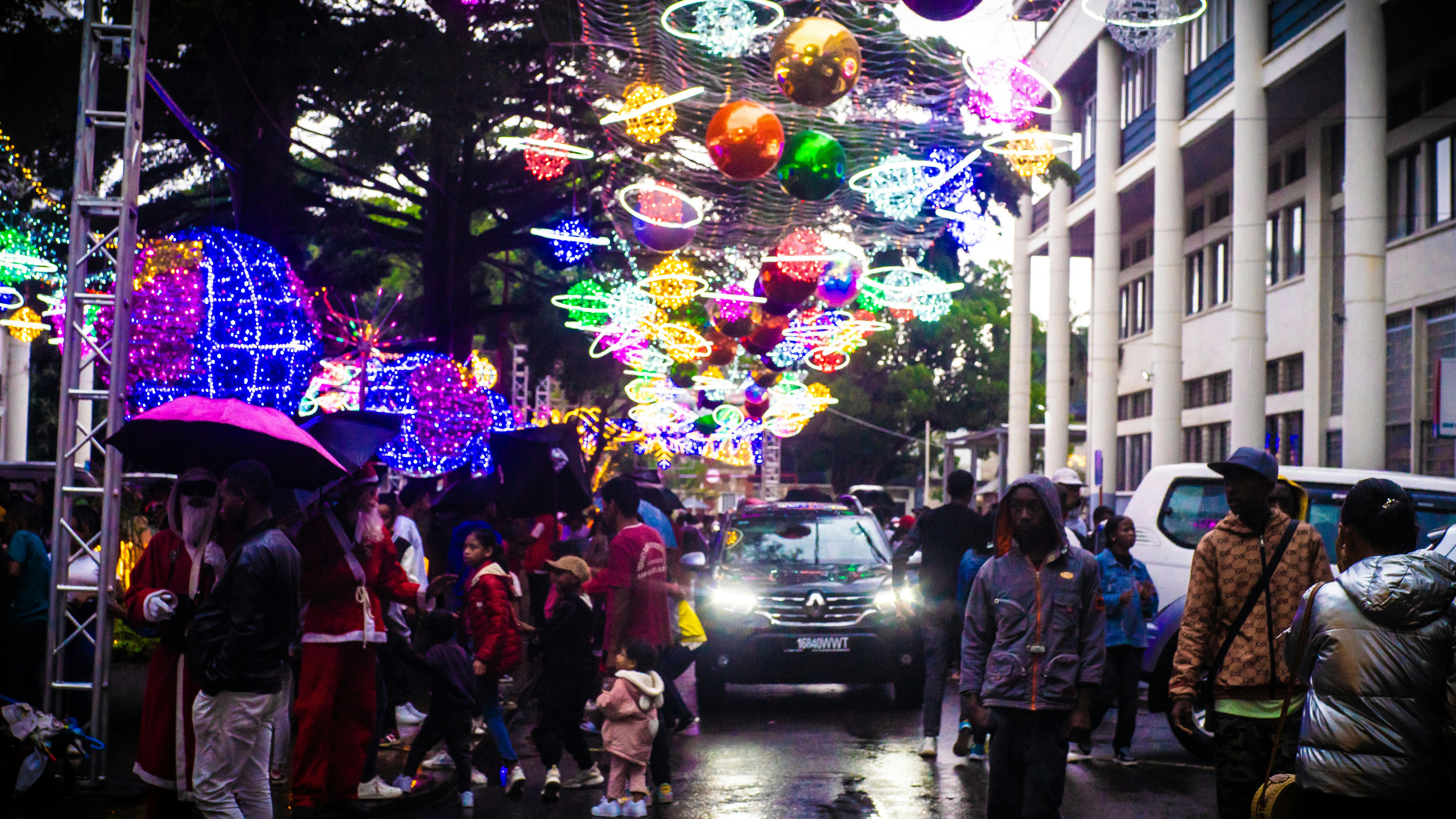  festive city street illuminated by orbiting orbs and crowd under a canopy of lights