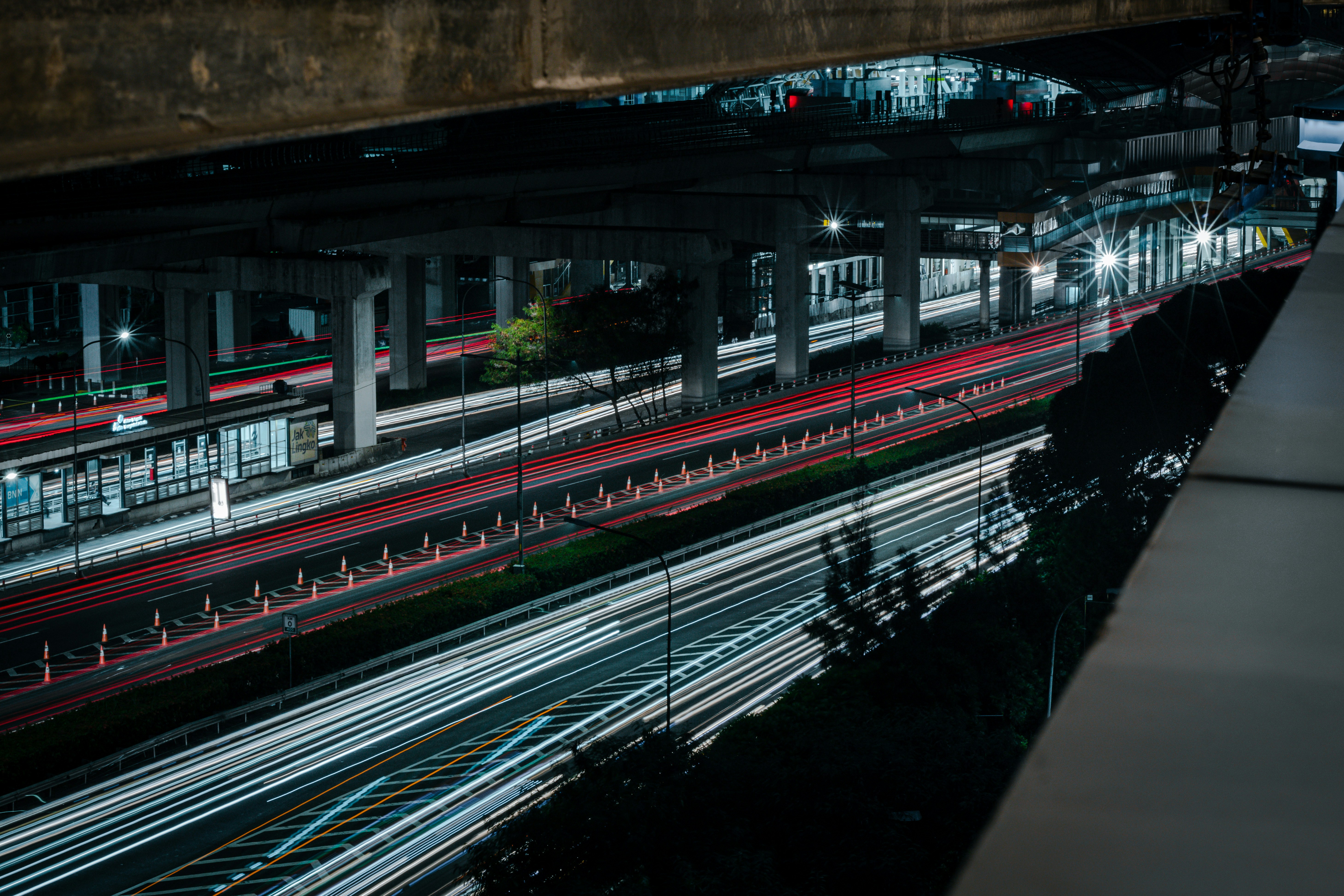 Nocturnal Grid: Light Trails Weaving Under the City’s Elevated Arteries