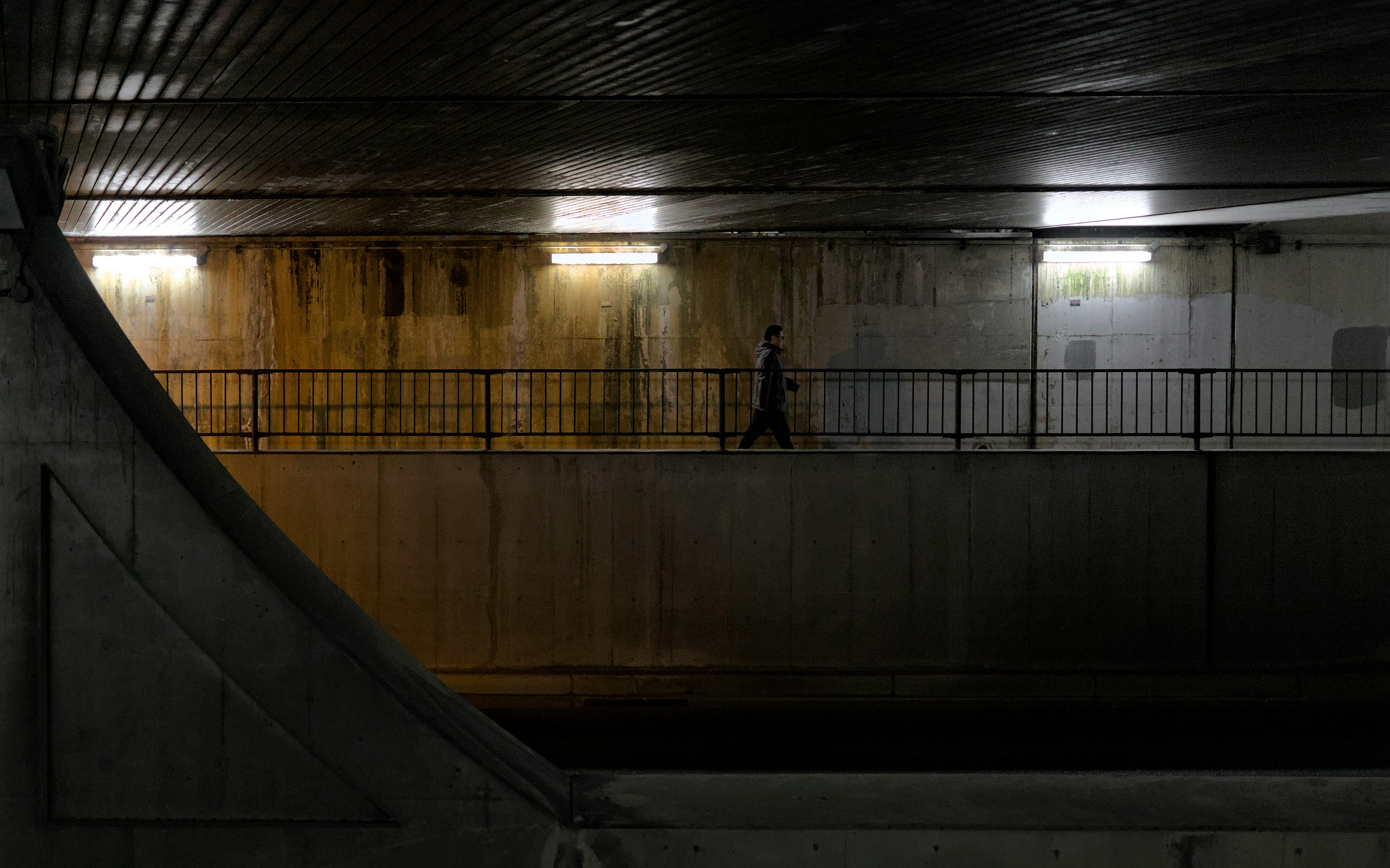 A person is walking down the sidewalk of an underpass in Kyoto, Japan. 2024-01-03 @ XPP4+CCX
