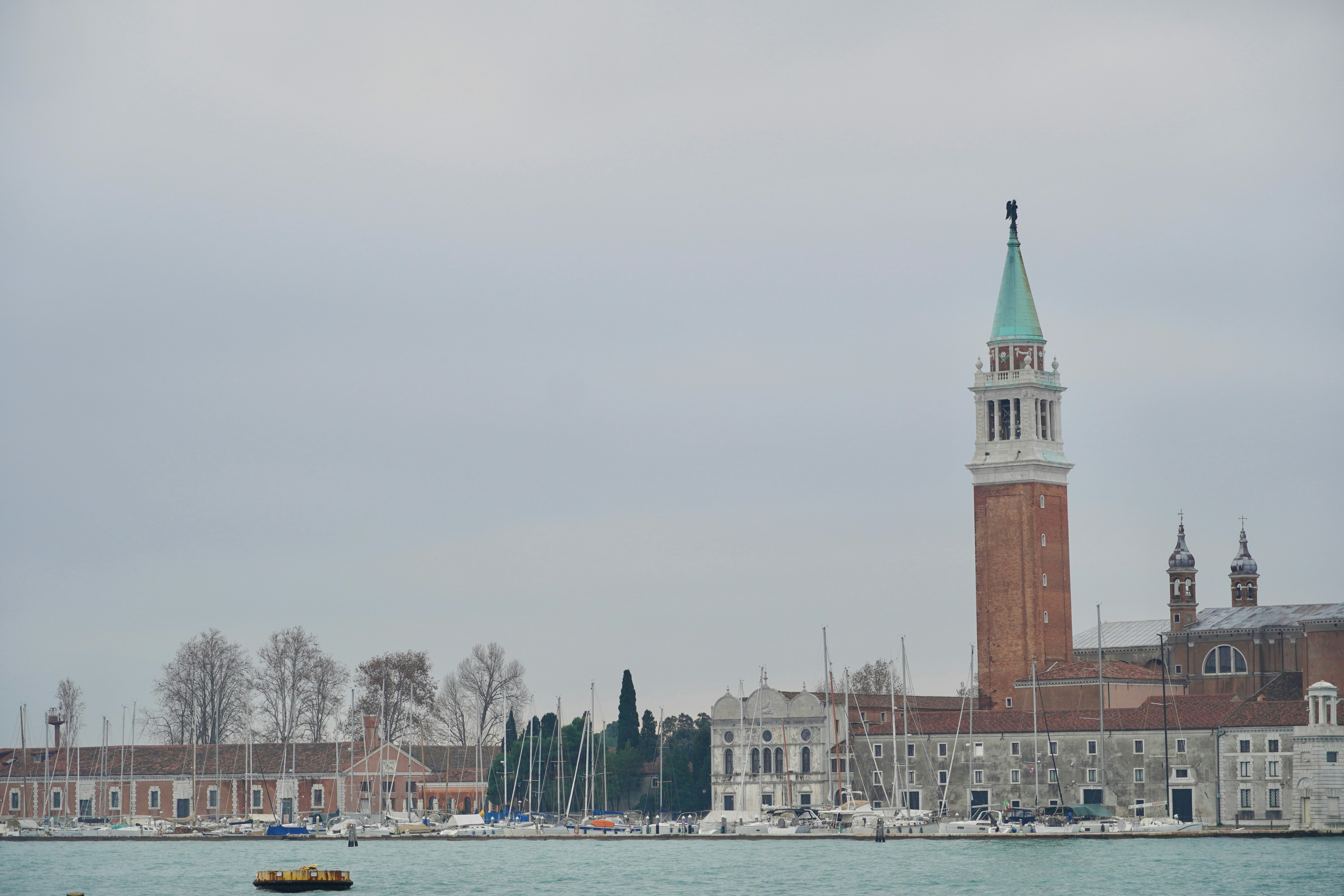 A large clock tower towering over a body of water photo – Free Grey ...