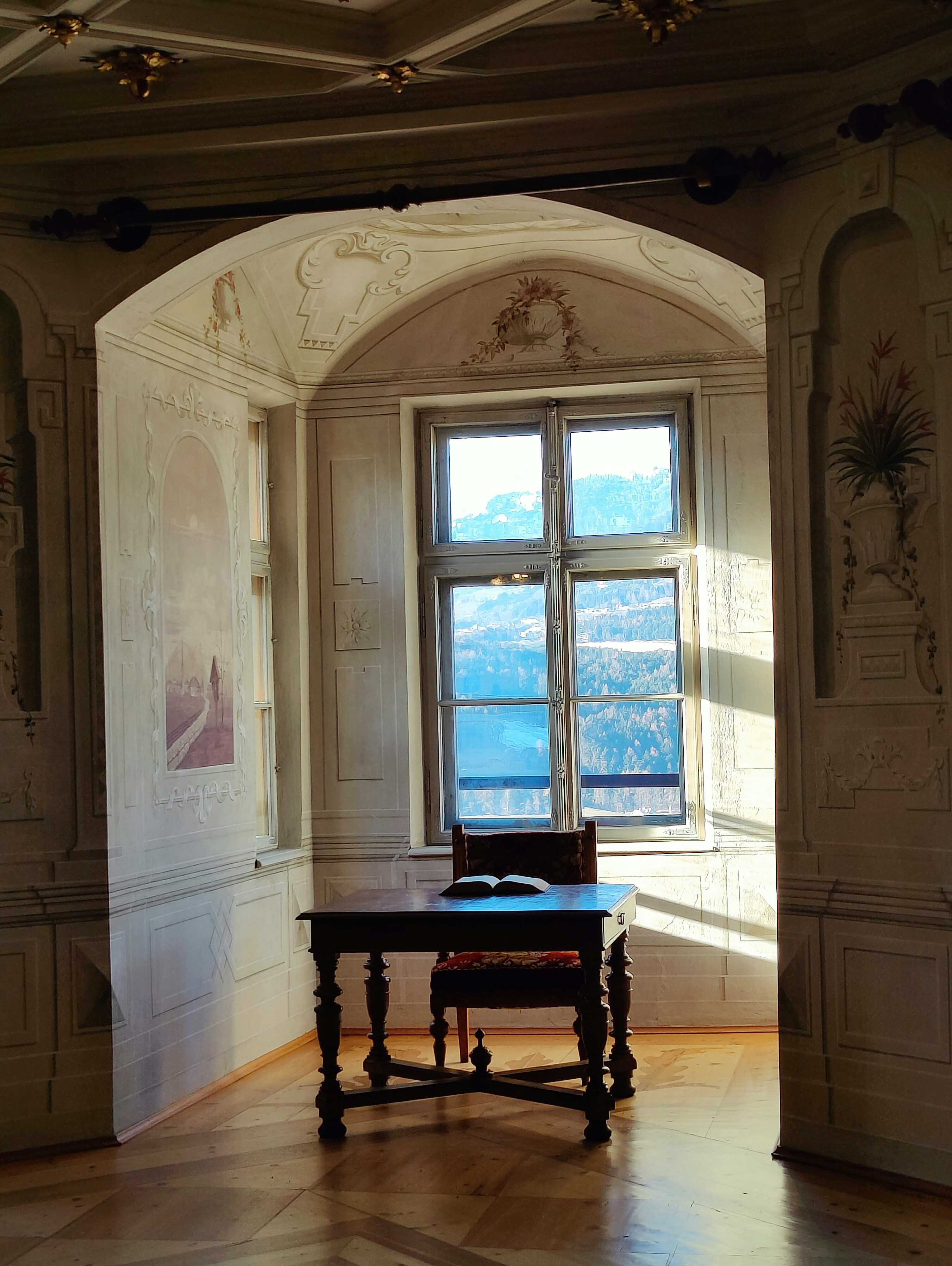 Window Light on a Carved Parlor: Desk Beneath a Mountain View