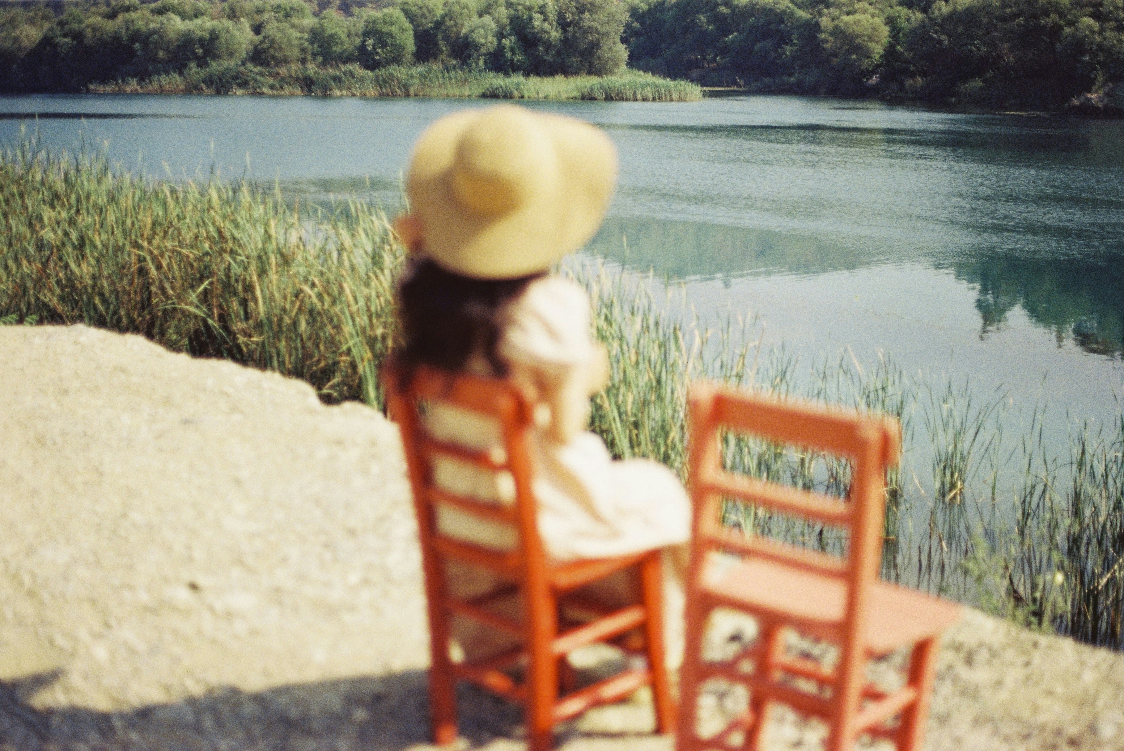 Lakeside Quiet: Hat, Chairs, and Soft Focus