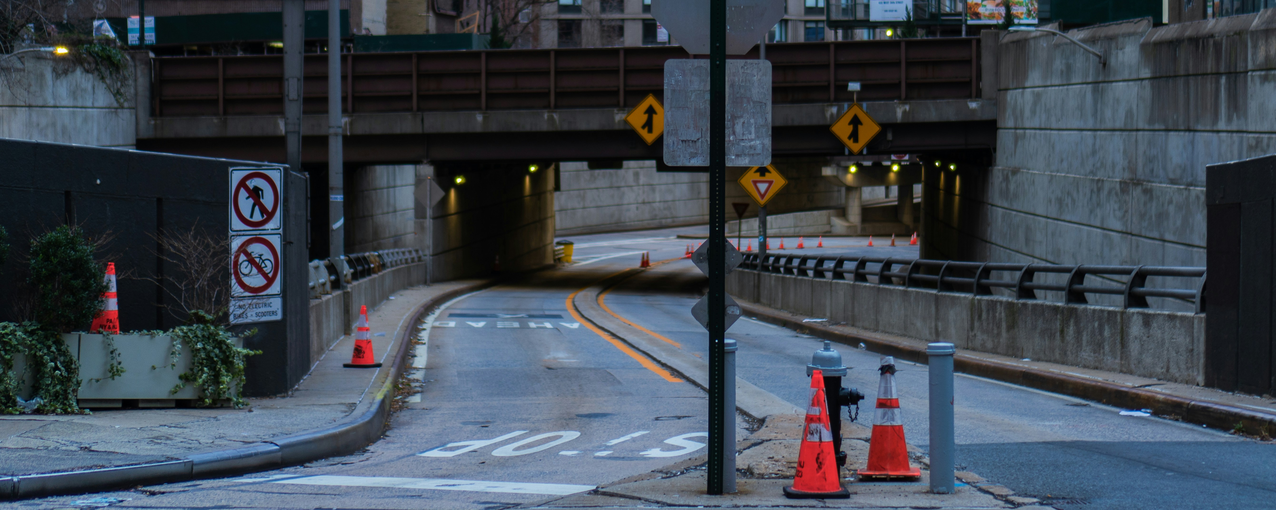 A city street with construction cones on the side of the road photo ...