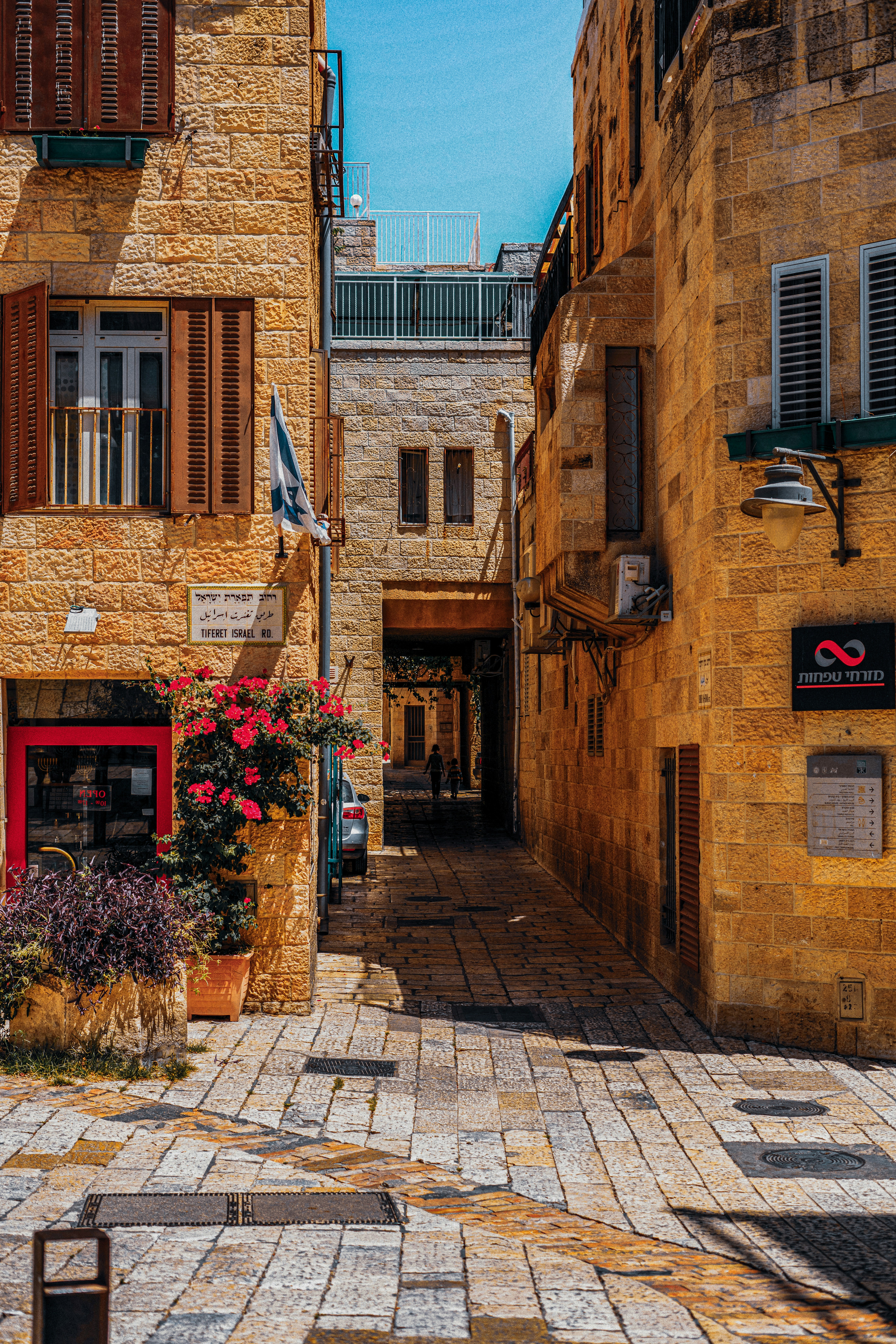 A cobblestone street lined with buildings and flowers photo – Free ...