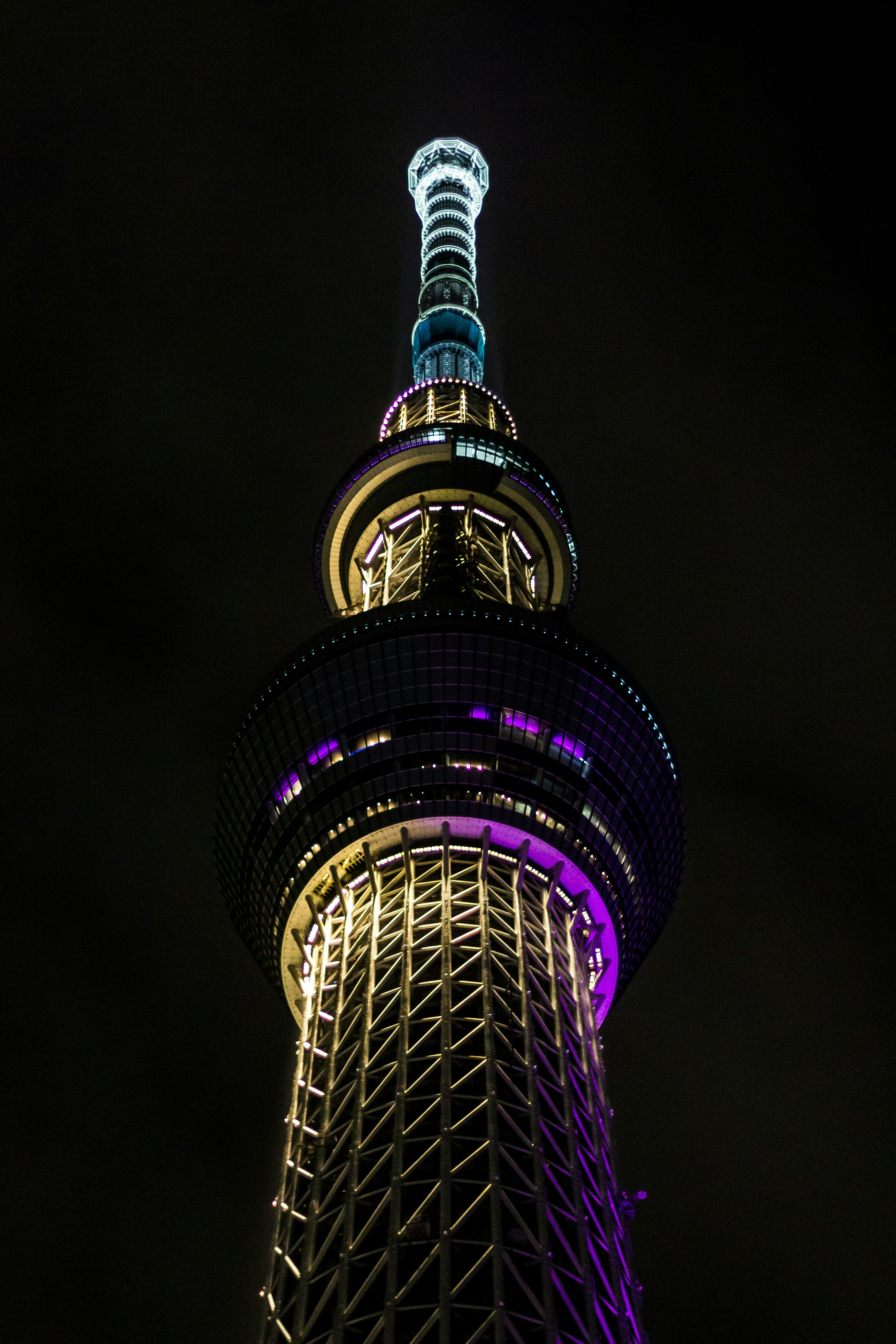 The top of a tall tower lit up at night photo – Free Japan Image on ...