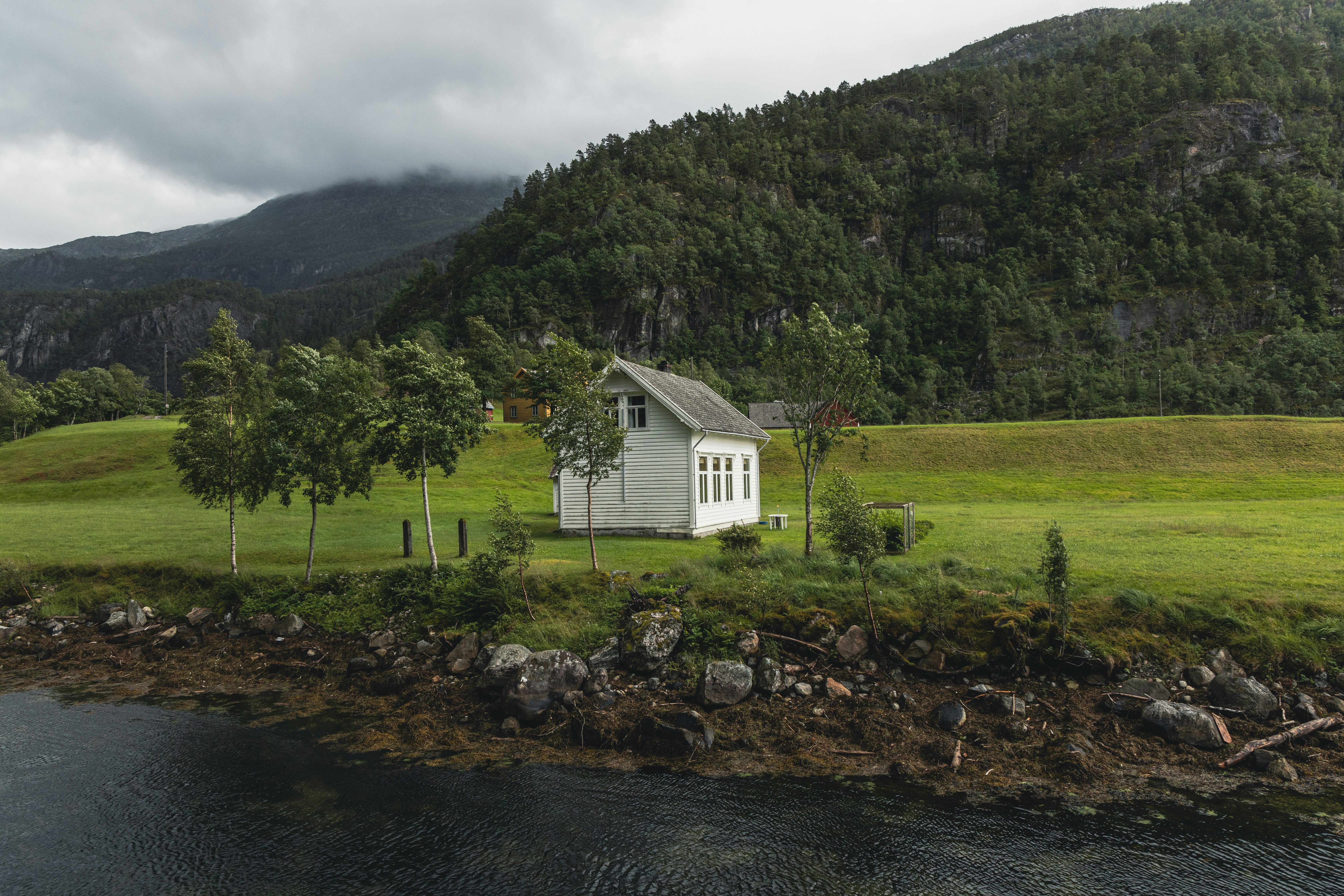 Lakeside White Cottage Framed by Quiet Hills and Calm Water
