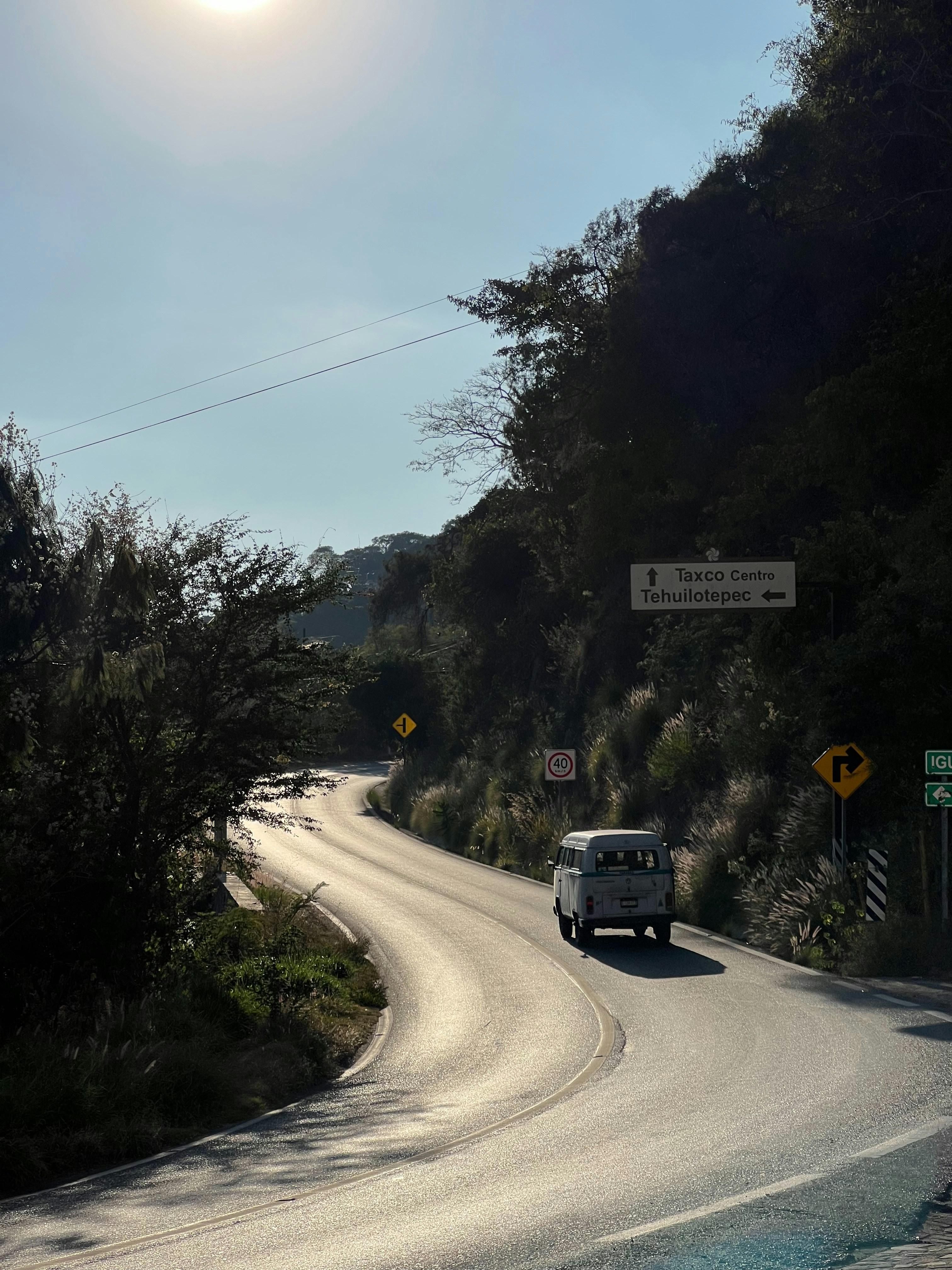 Sunlit Hairpin: A Retro Van Navigates a Quiet Mountain Bend