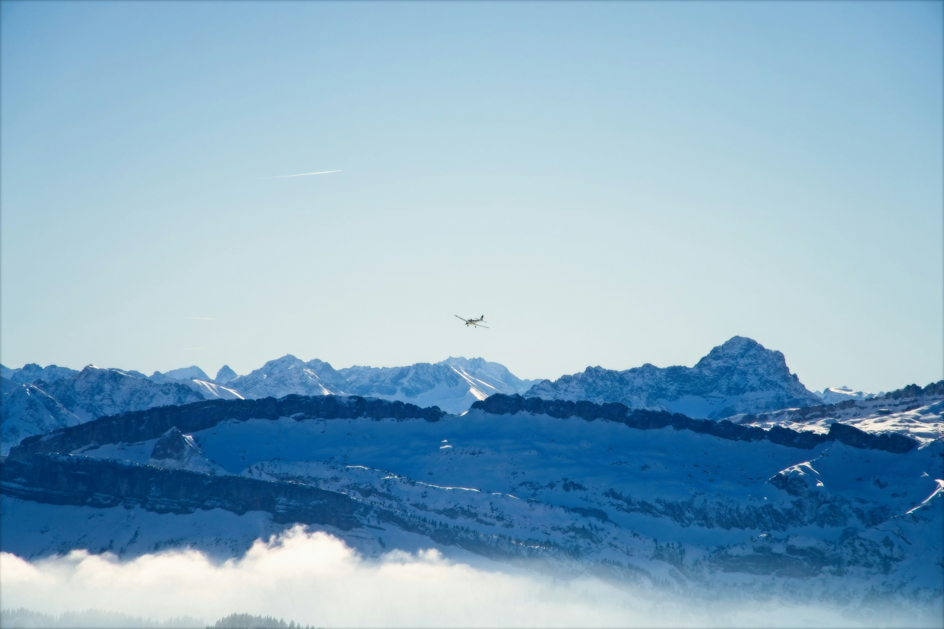 Aerial Dawn: Lone Jet Over Serrated Mountains