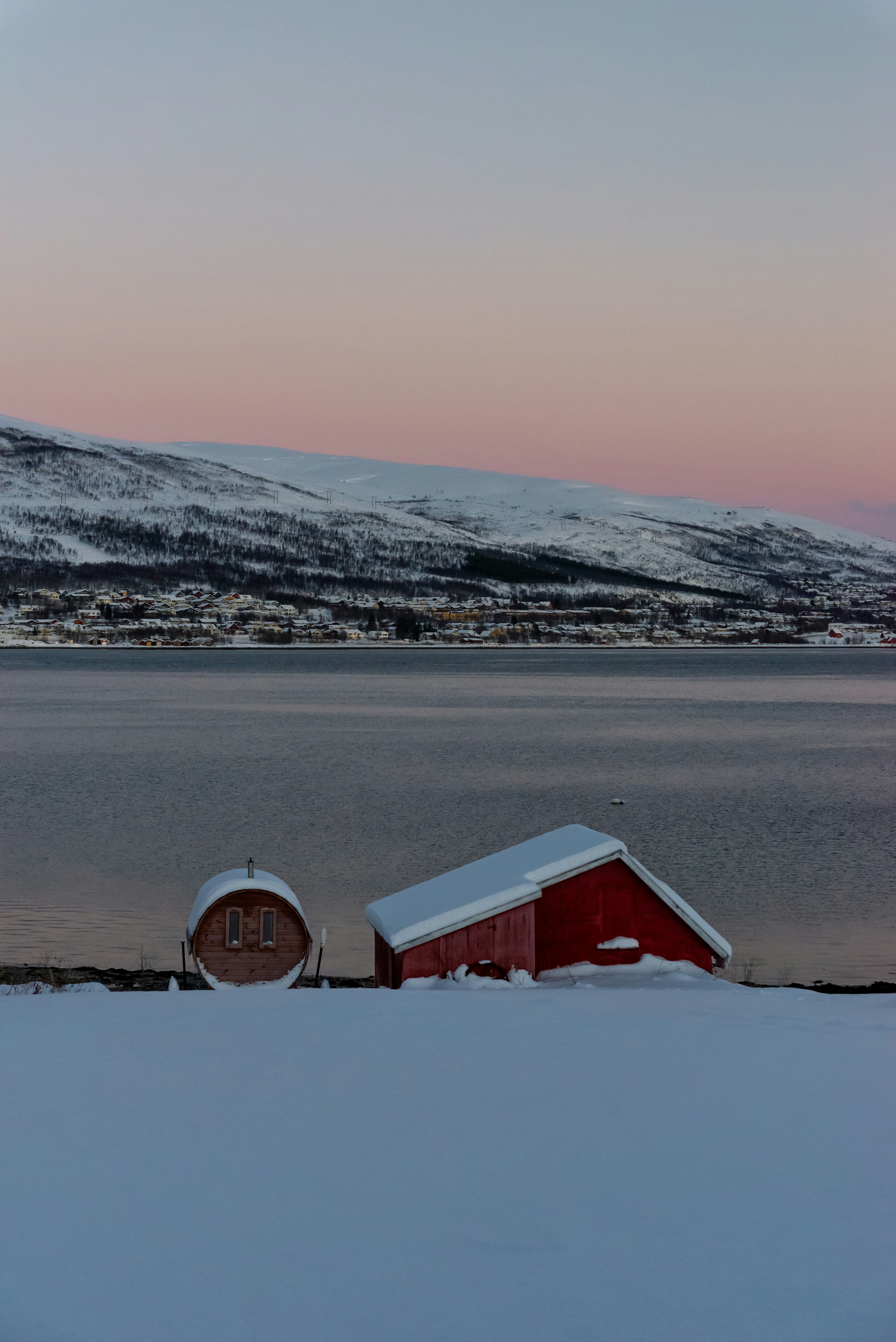 Crimson Sheds by a Frosted Fjord at Sunset