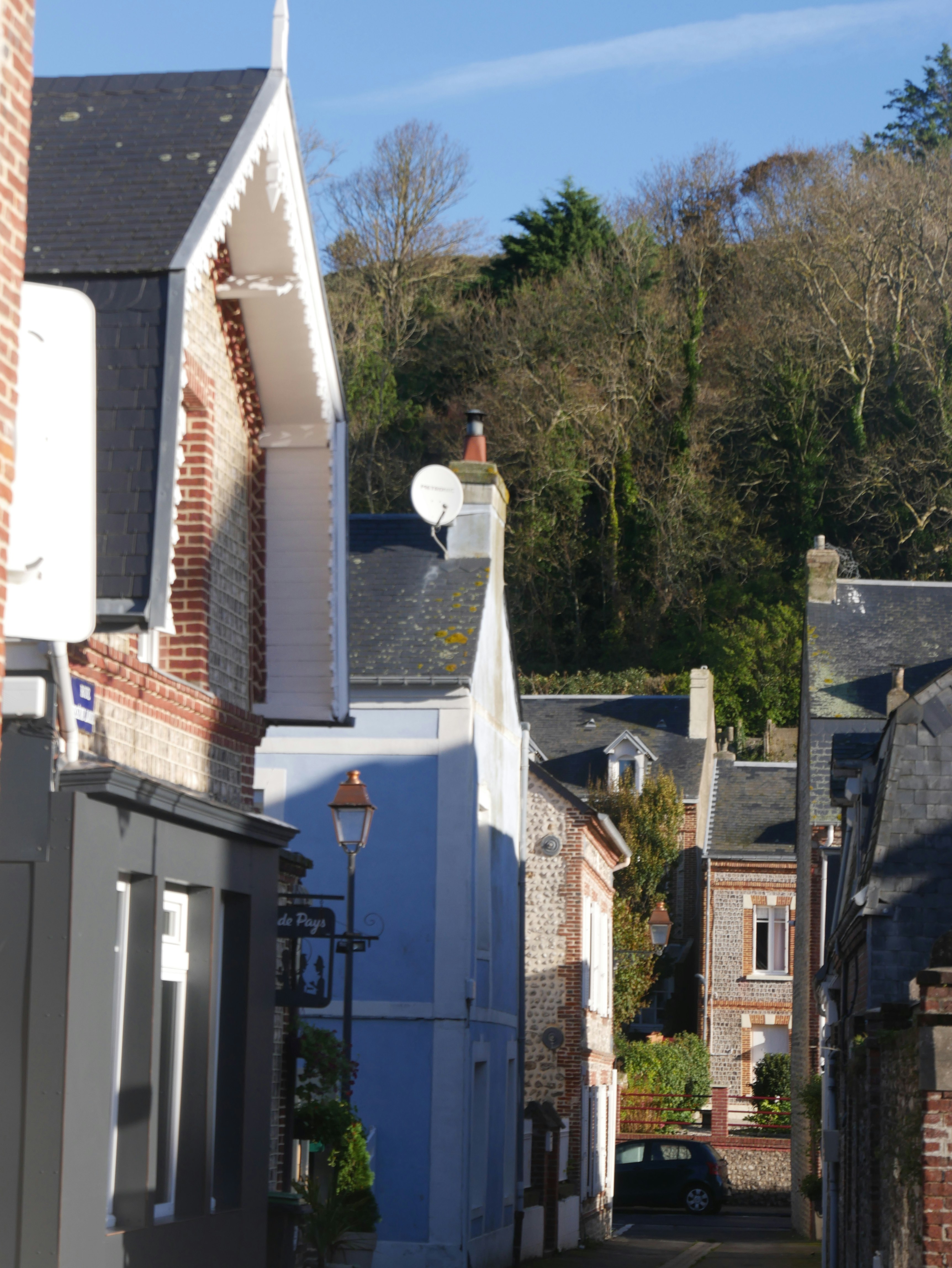 a narrow street with a church steeple in the background