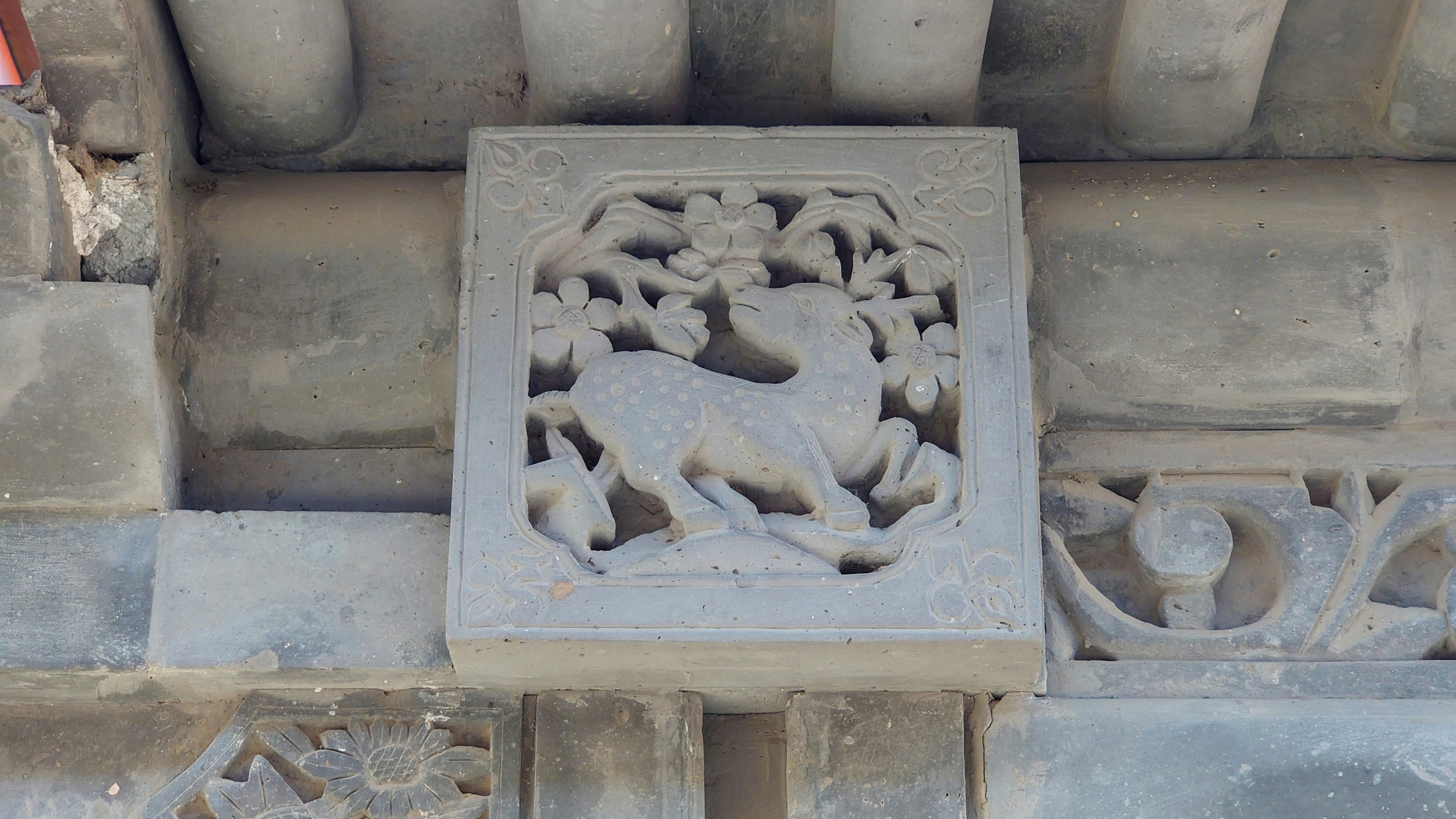 Stone Carved Unicorn Panel Nestled in Ancient Cornice