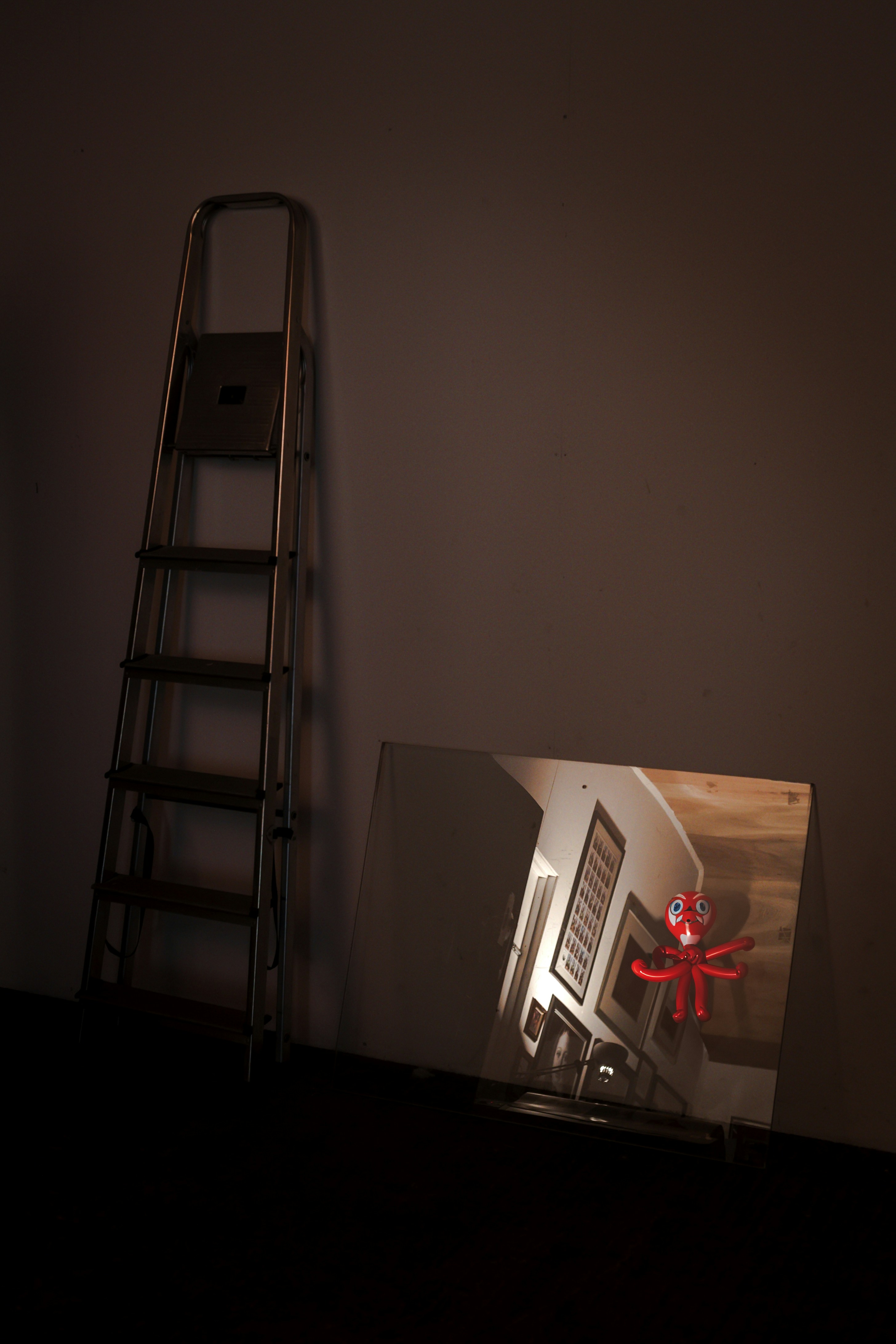 Ladder to Oddity: A Red Octopus in a Quiet Studio