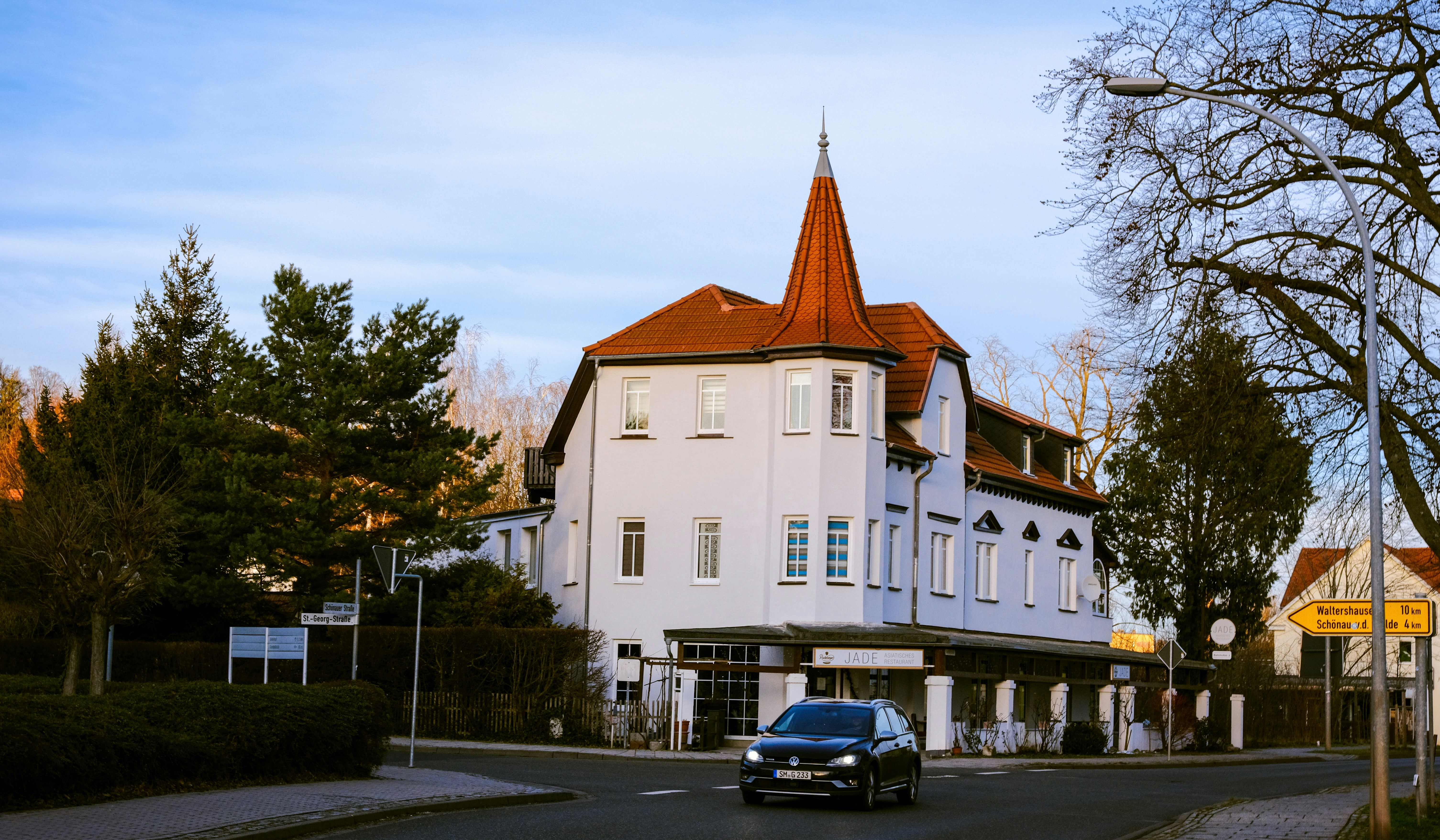 White Villa with Turret and Orange Roof on a Tranquil Town Street