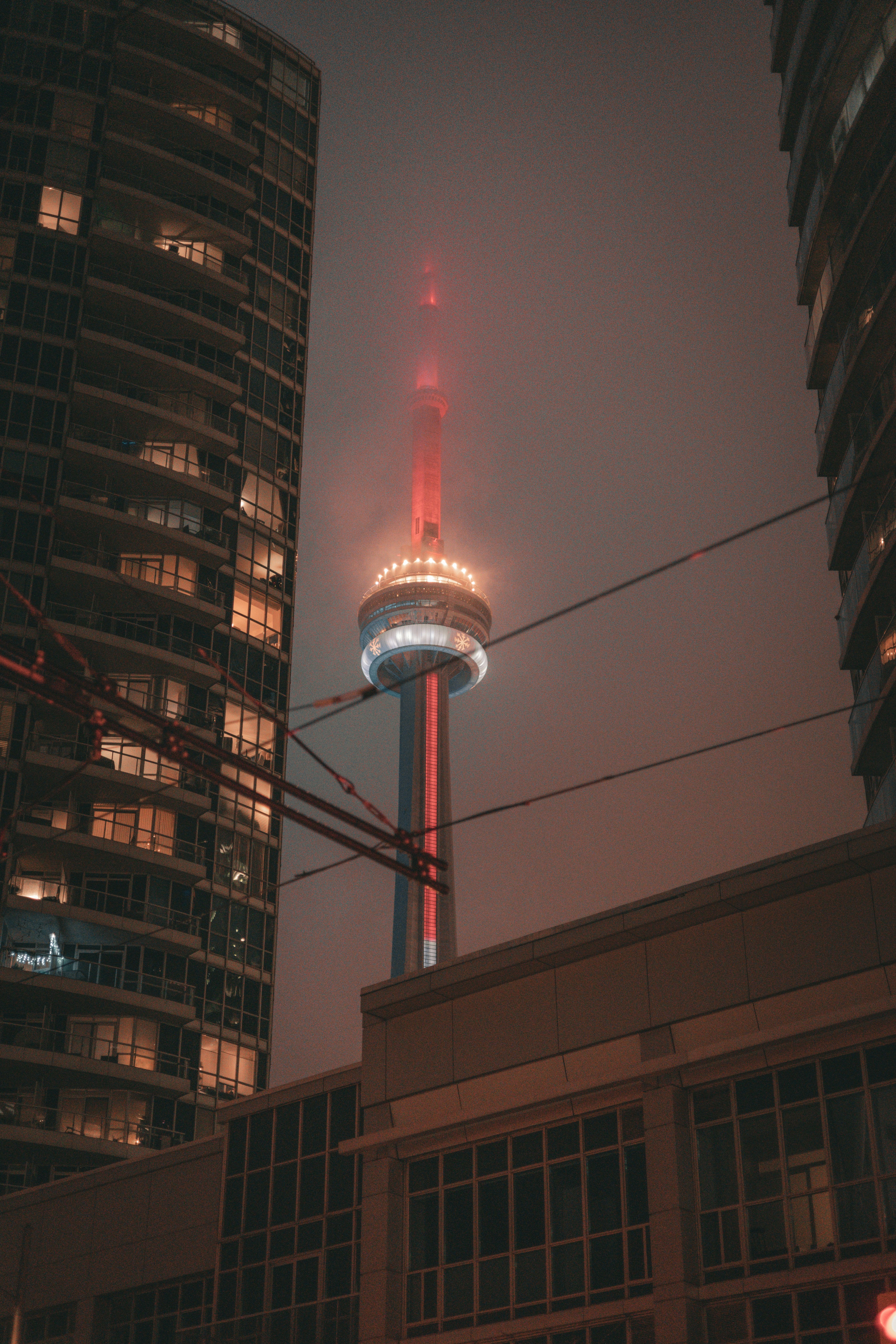A tall building with a red light on top of it photo – Free Cn tower ...
