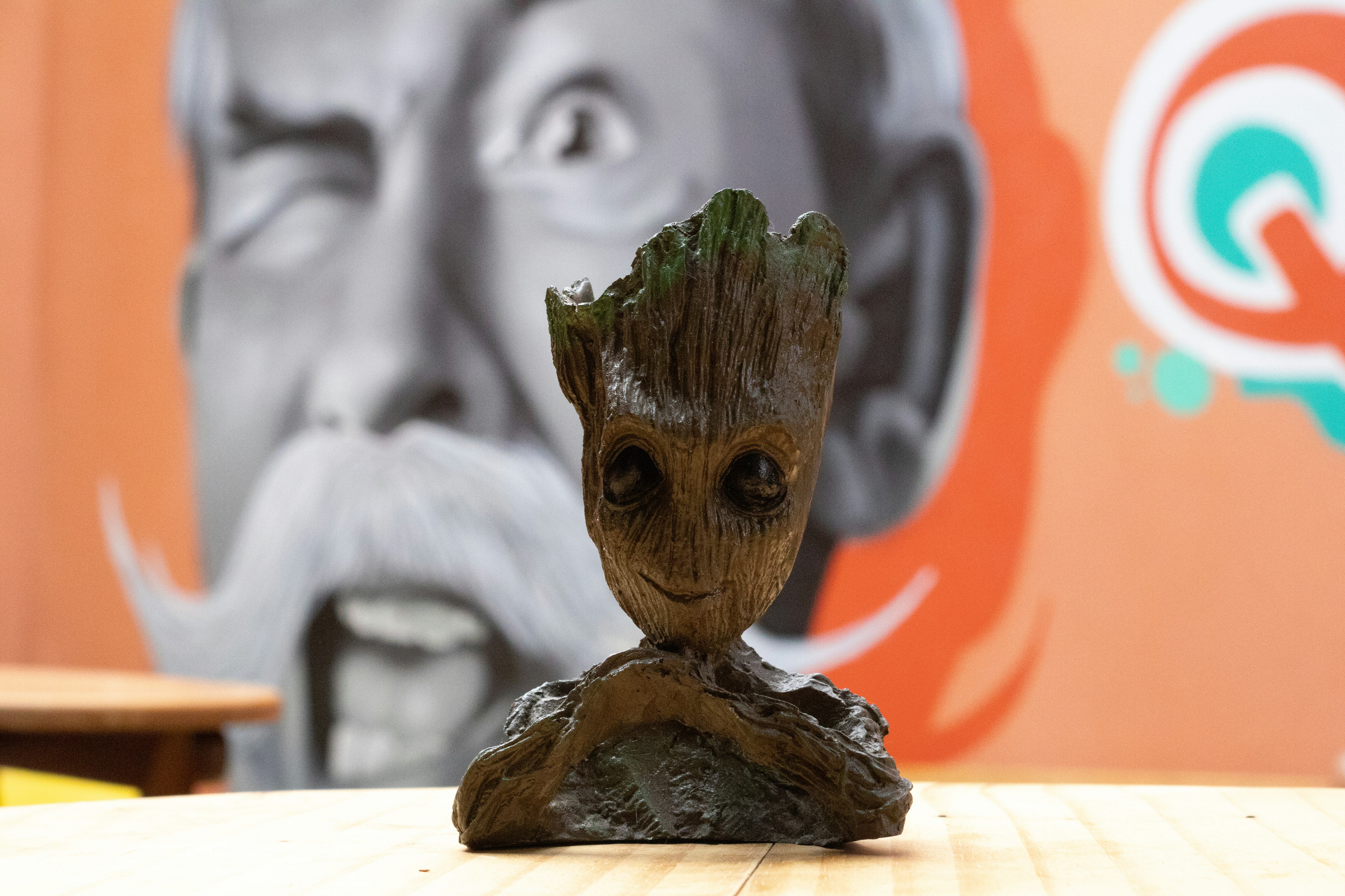 A small statue of a groote sitting on top of a wooden table photo ...