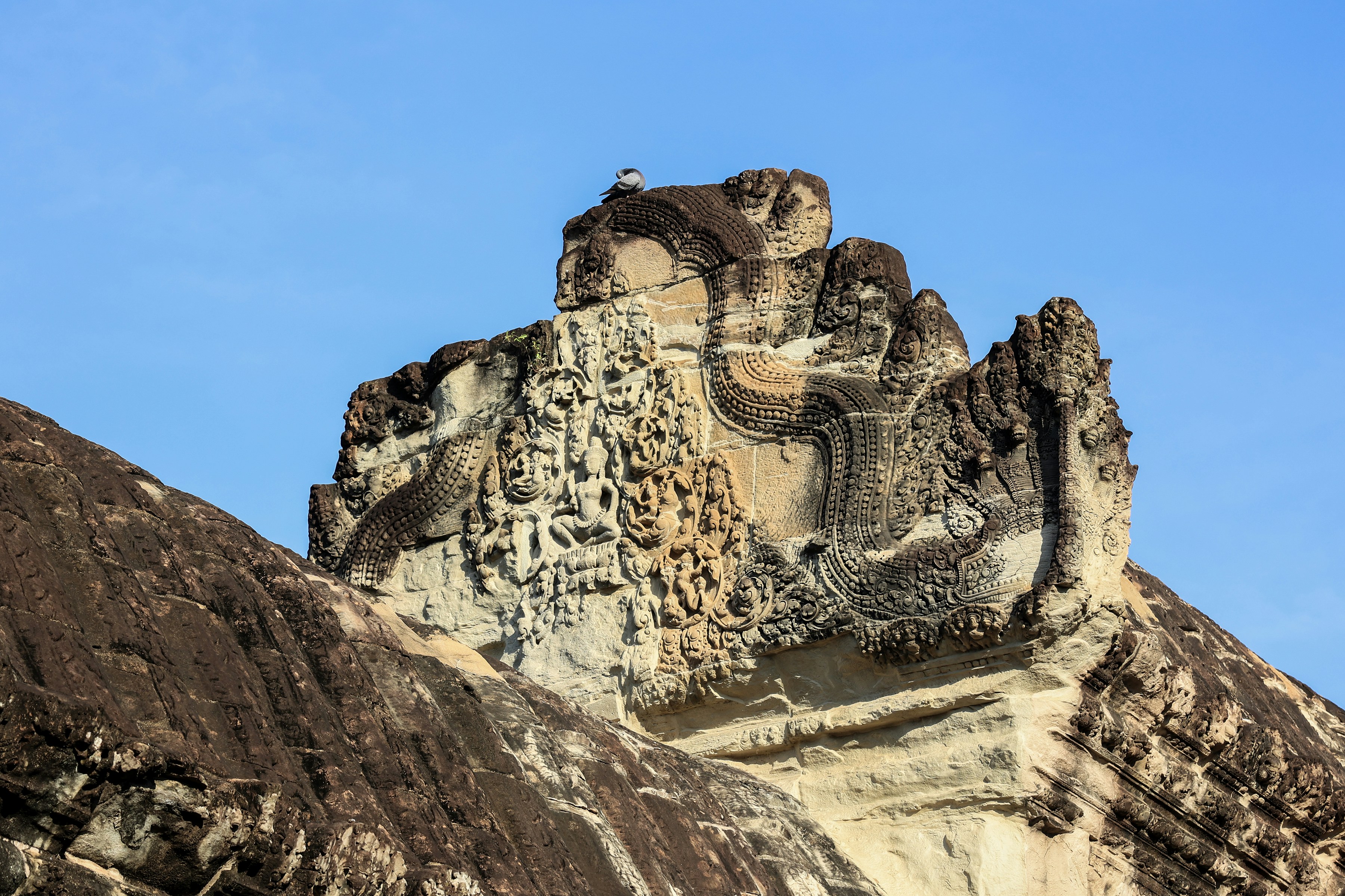 A large stone structure with carvings on the side of it photo – Free ...