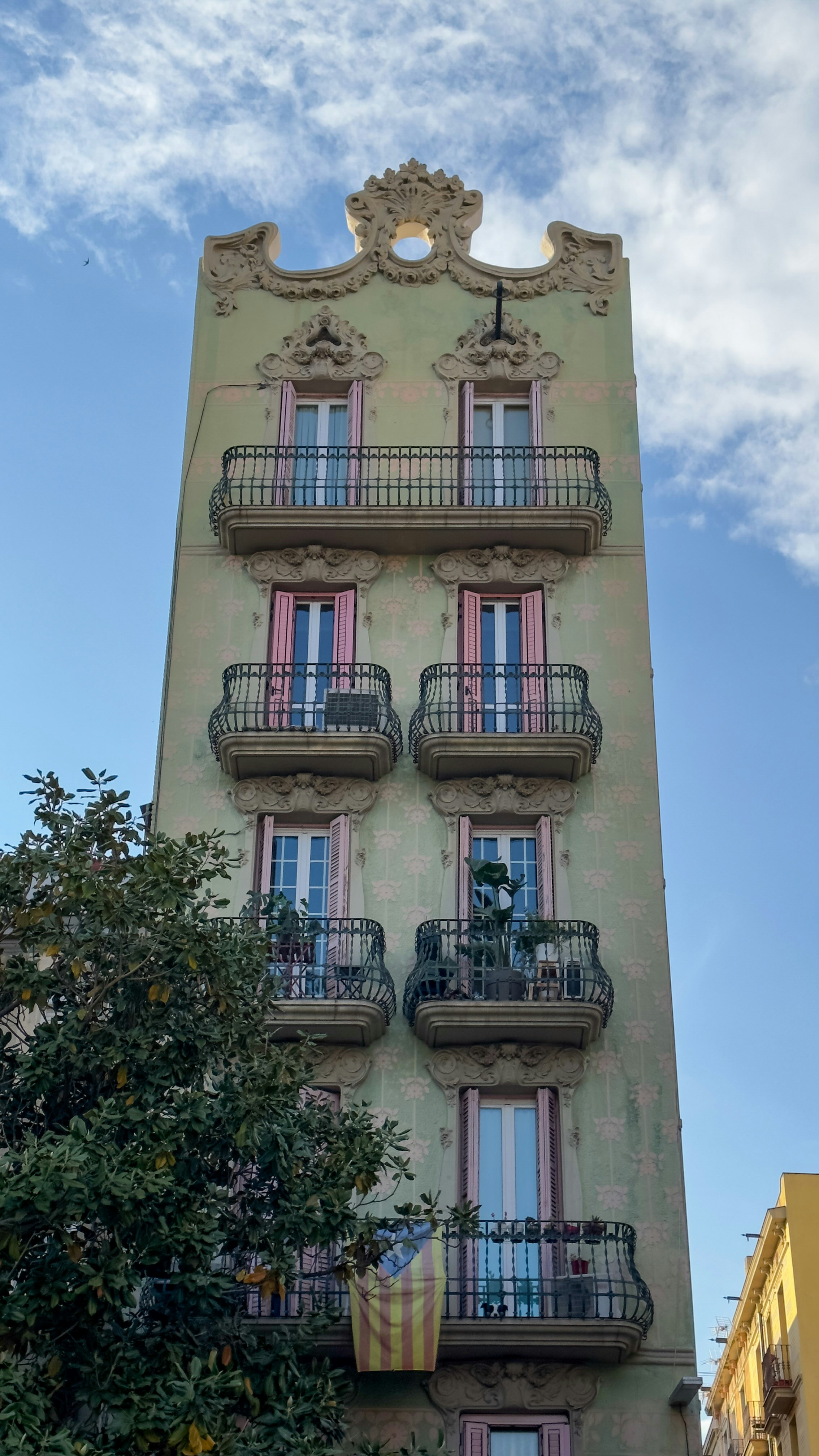 Green Facade with Pink Balconies: A Vertical Gallery of Iron Lace