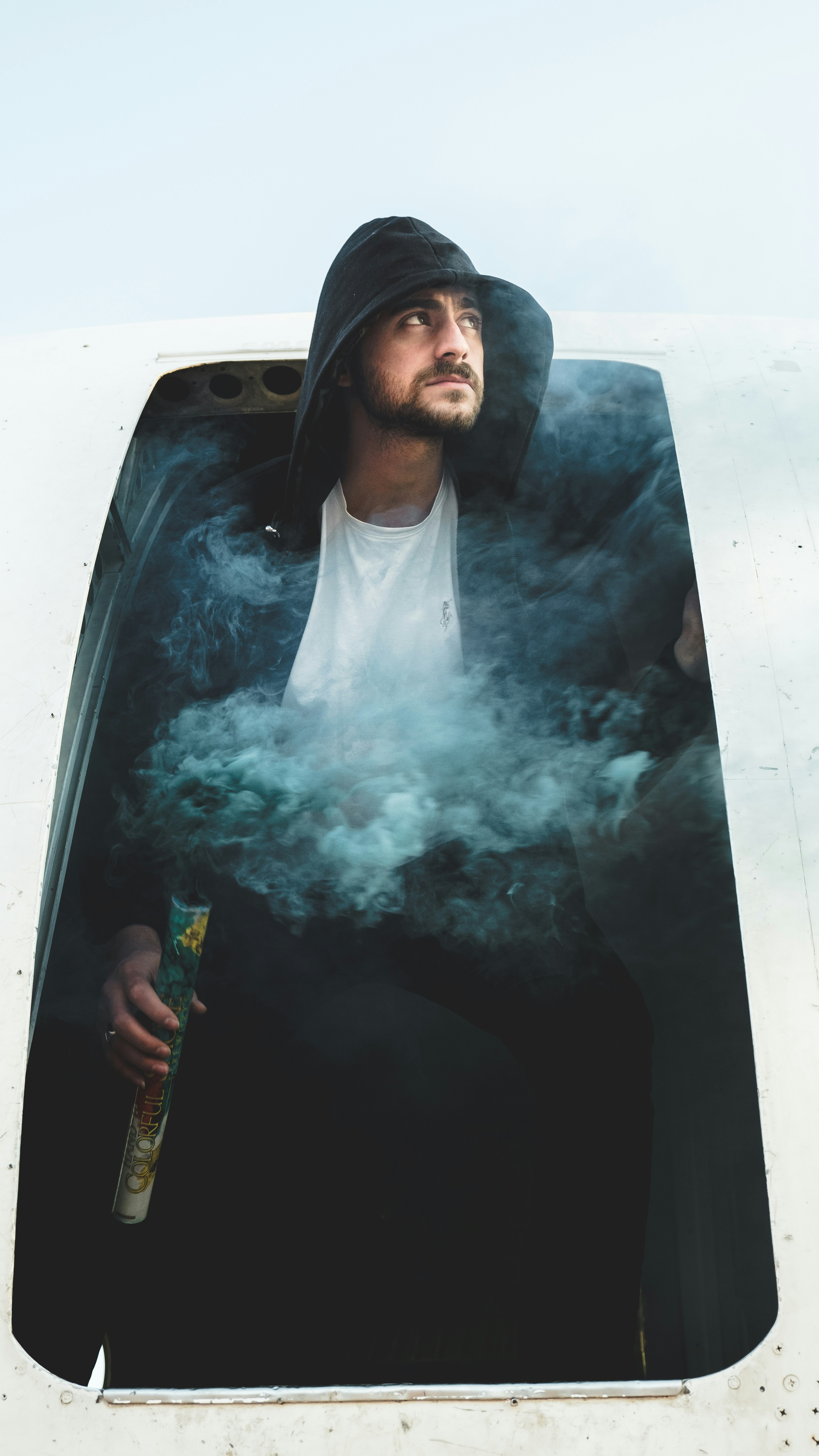 Hooded Figure at the Aircraft Door, Surrounded by Smoke