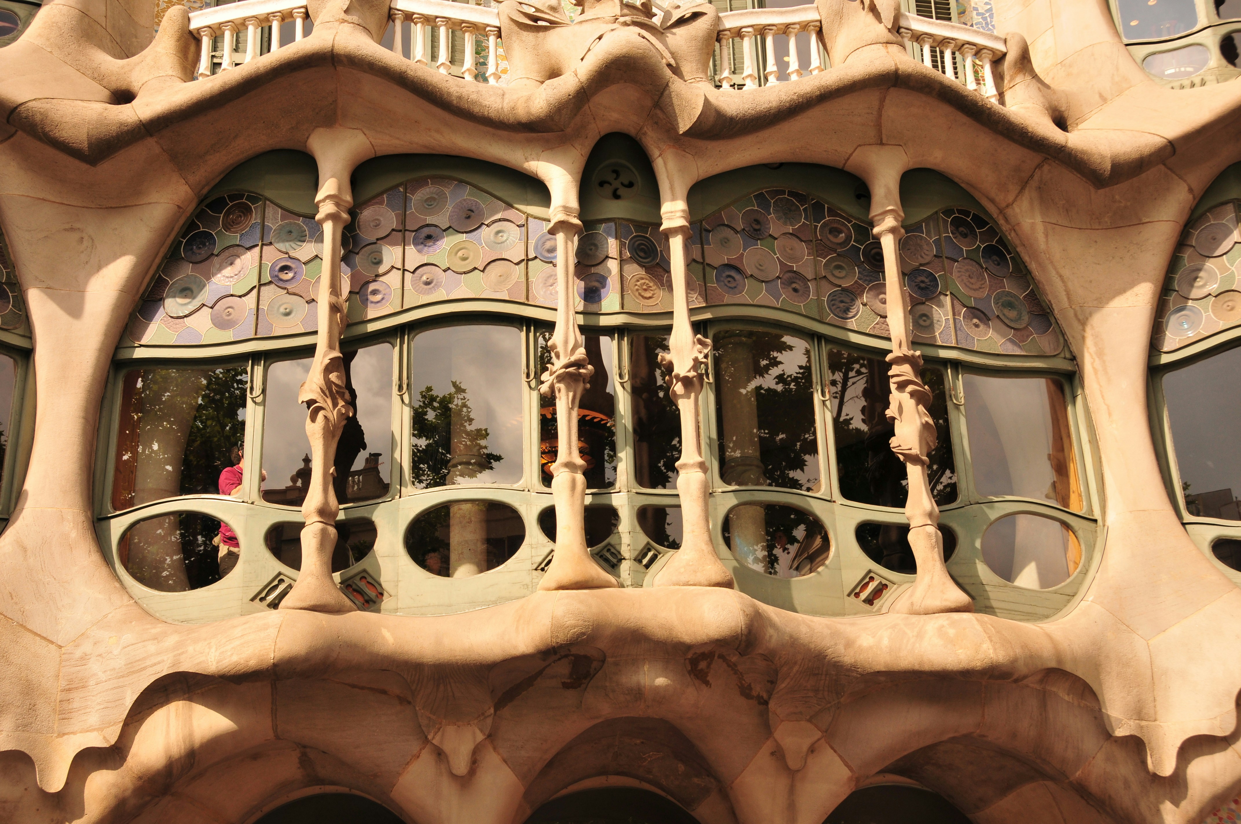 Organic stonework and stained-glass rind: Gaudí-inspired facade in warm light