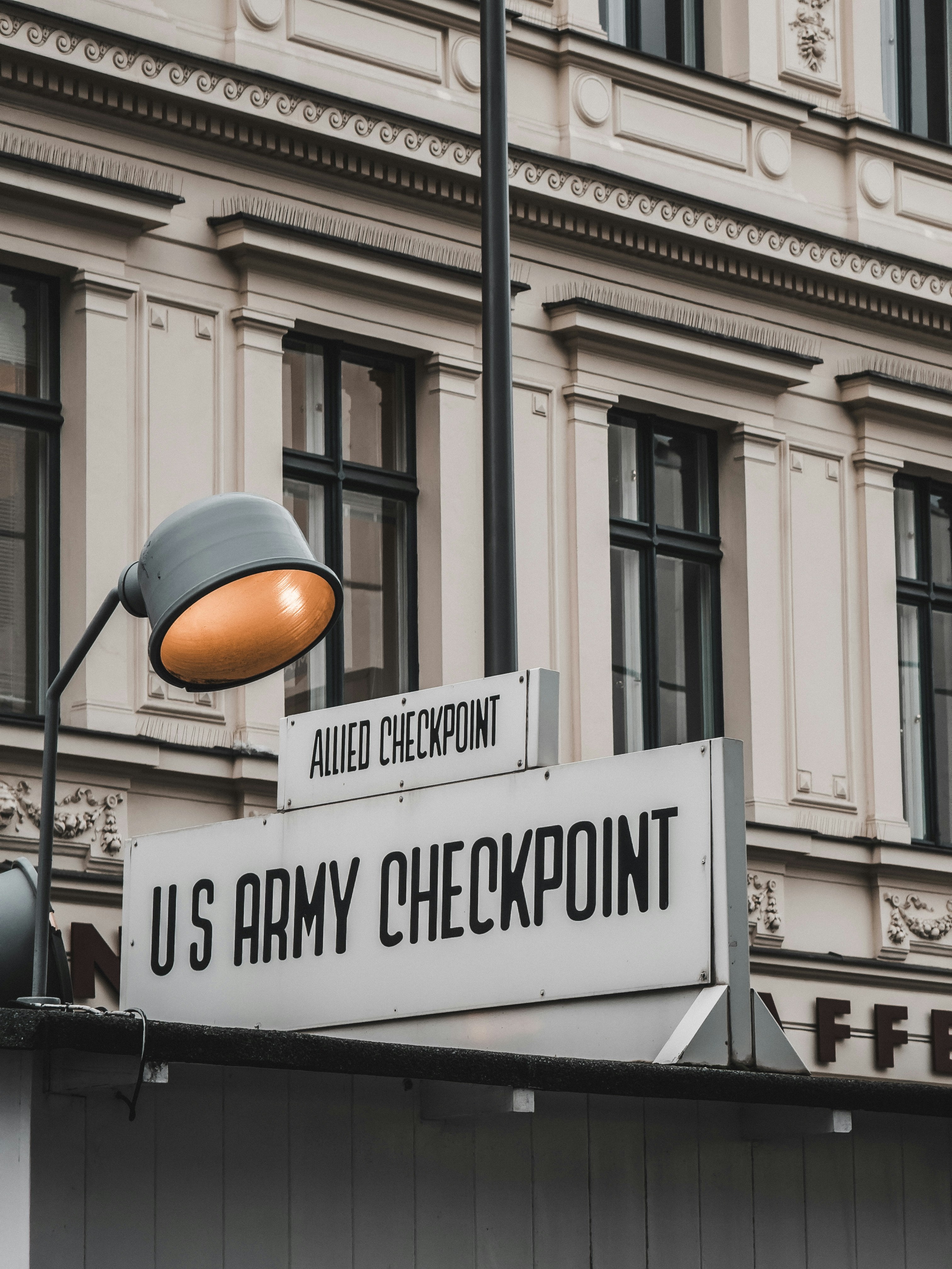Allied Checkpoint Sign Nestled Under a Classical City Facade