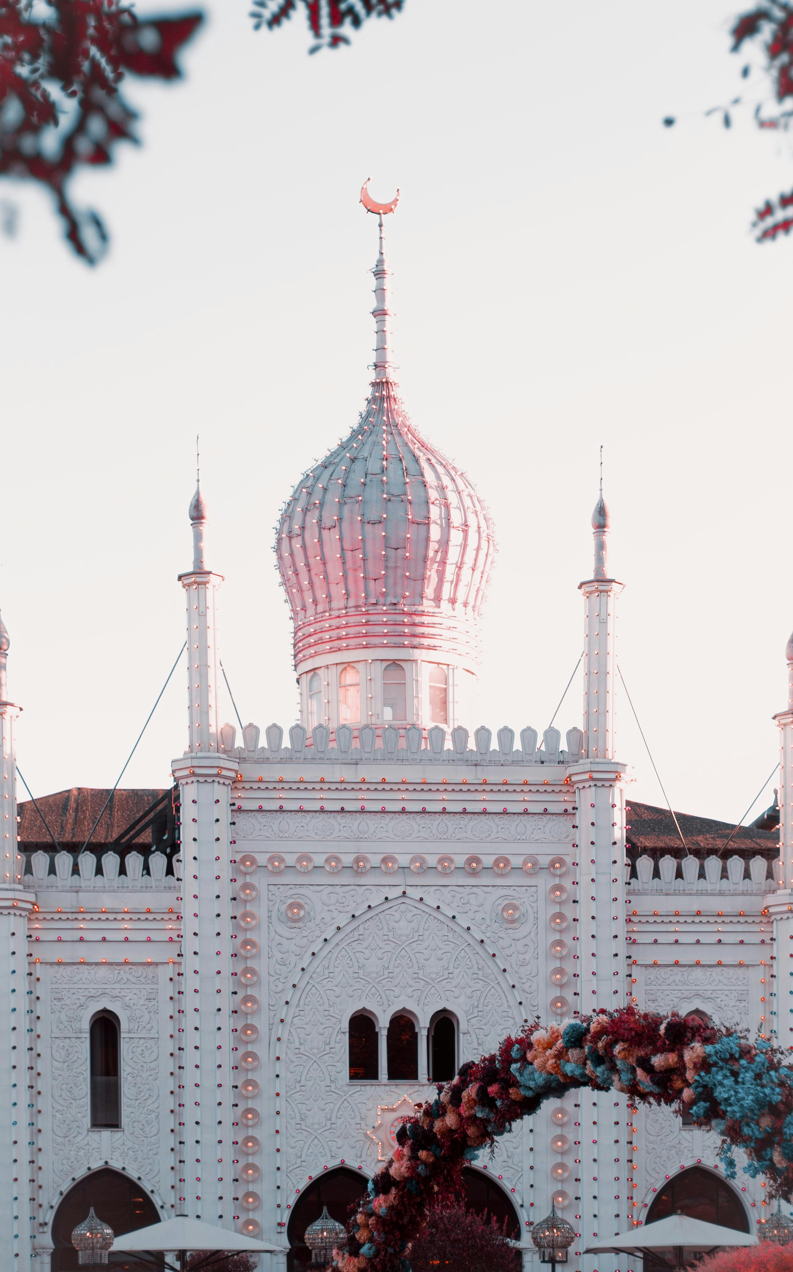 Crescent Crown Over a White Moorish Facade Framed by a Floral Arch