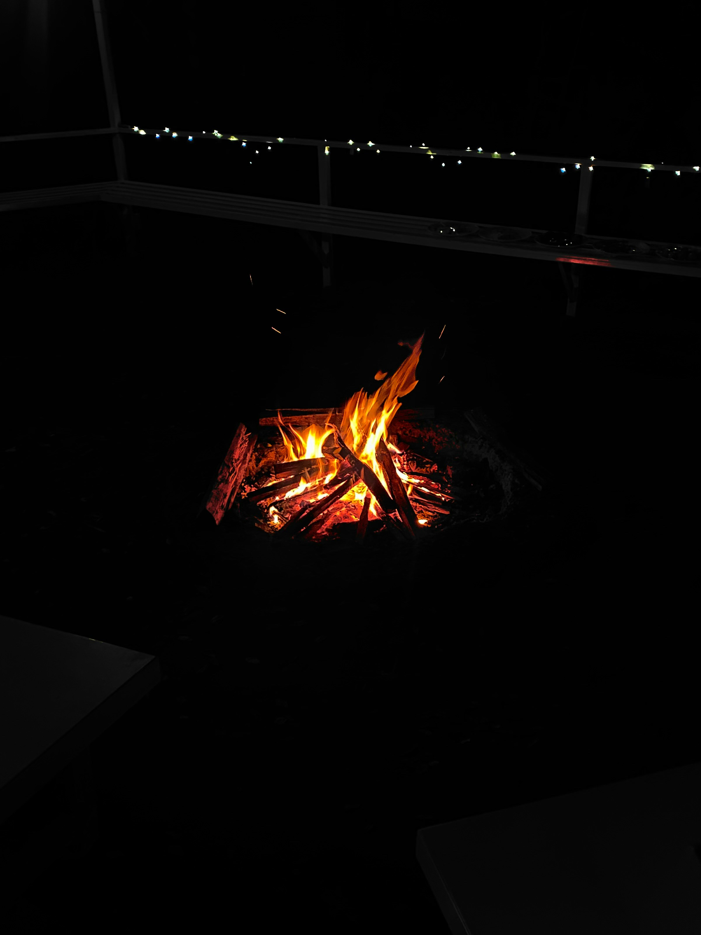 Midnight Ember: Firelight on a Quiet Deck Under String Lights