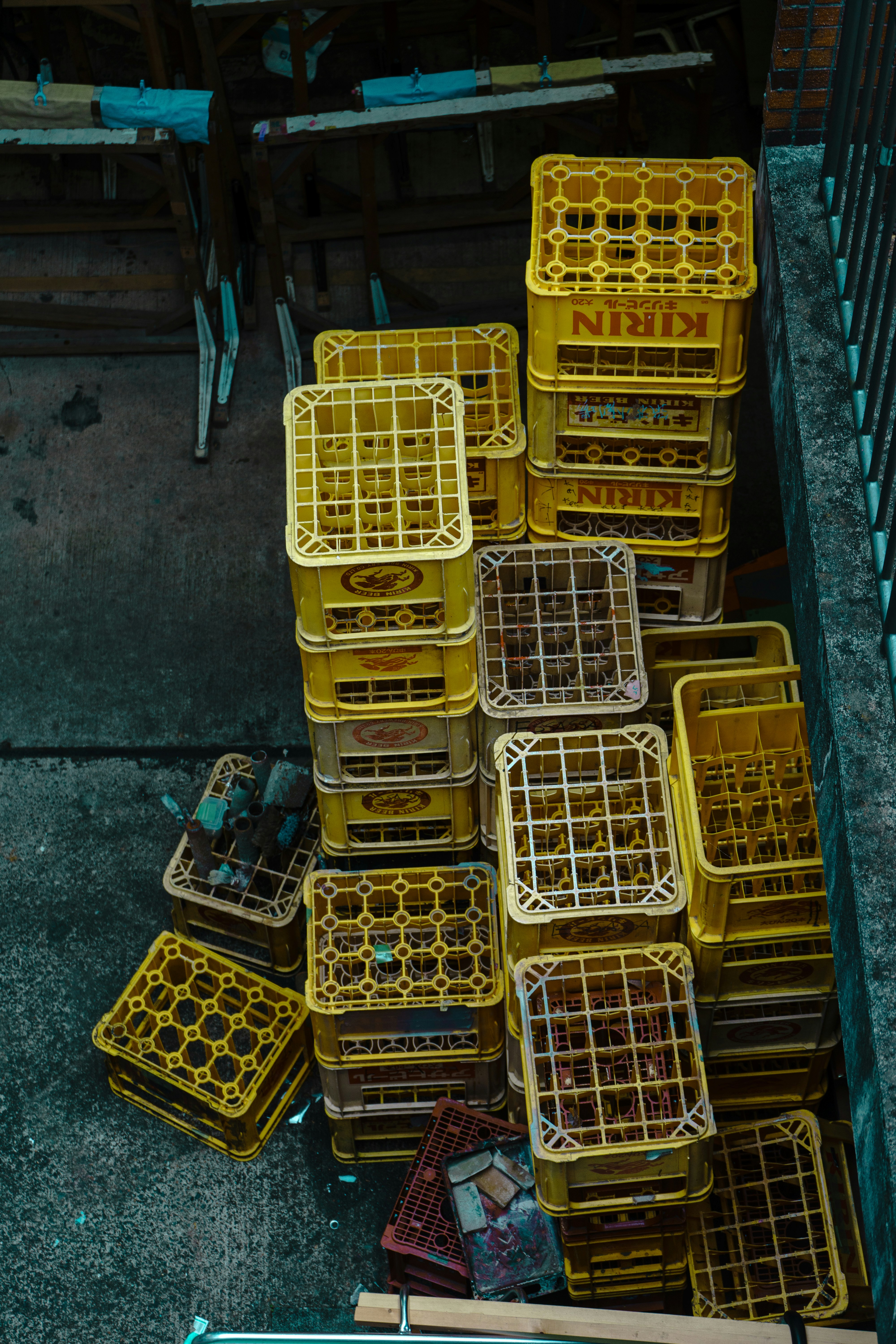 A vibrant arrangement of yellow crates stacked haphazardly in an urban setting, showcasing the intersection of color and structure. The scene captures the essence of city life and resourcefulness.