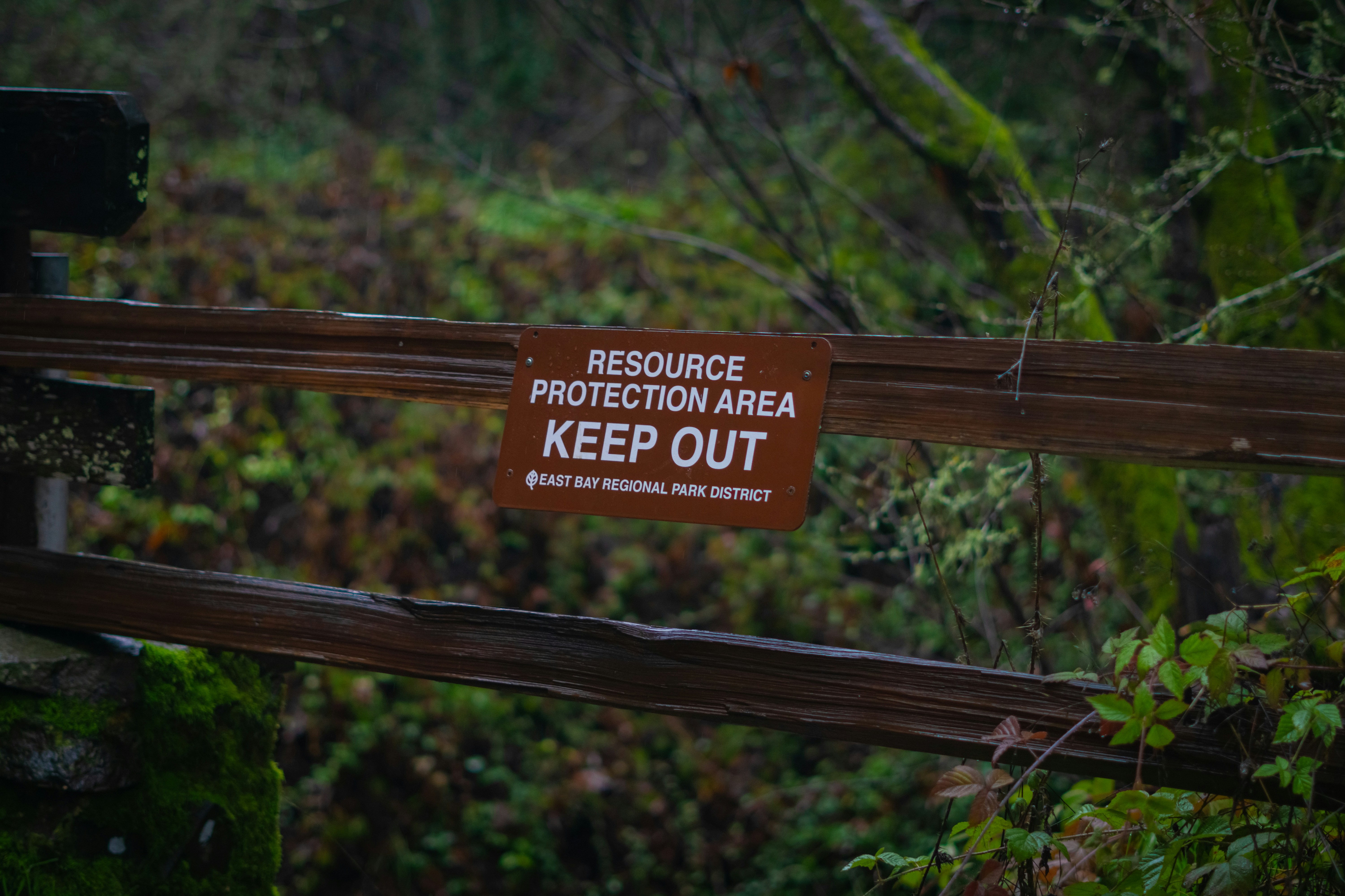A wooden fence with a sign on it that says, resources protection area ...