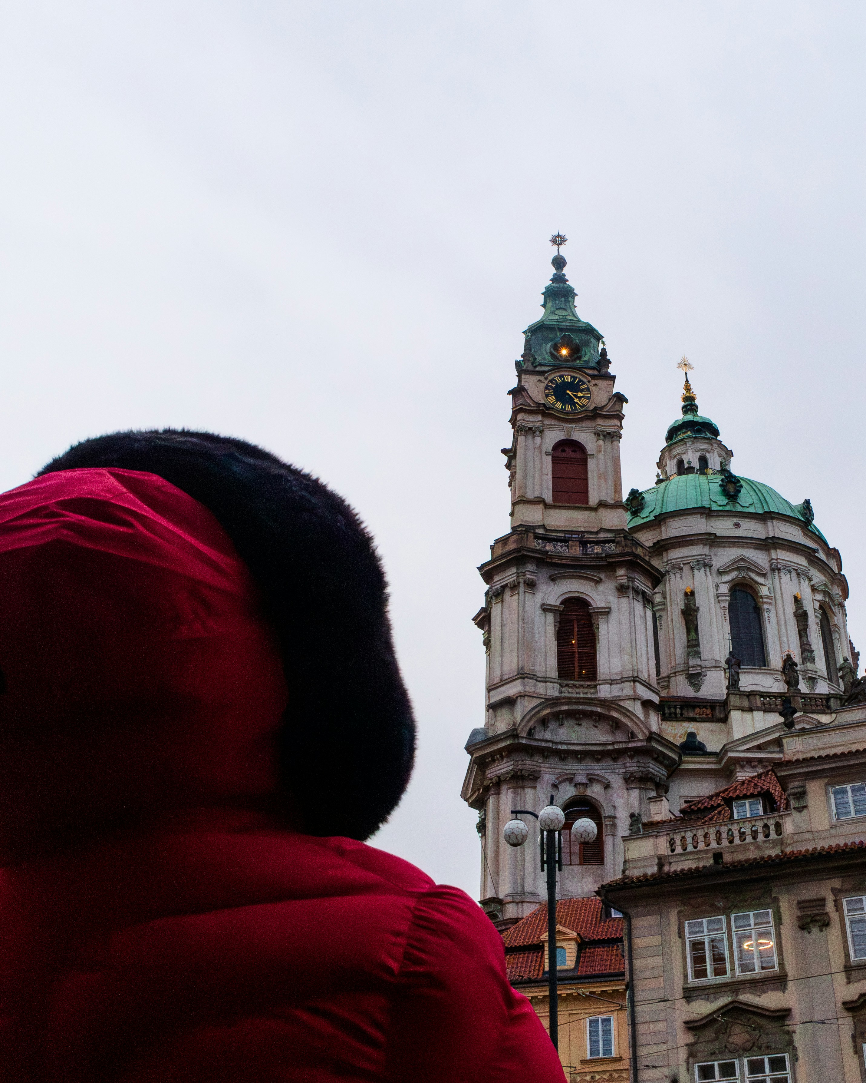 A person in a red coat looking at a building photo – Free Malá strana ...
