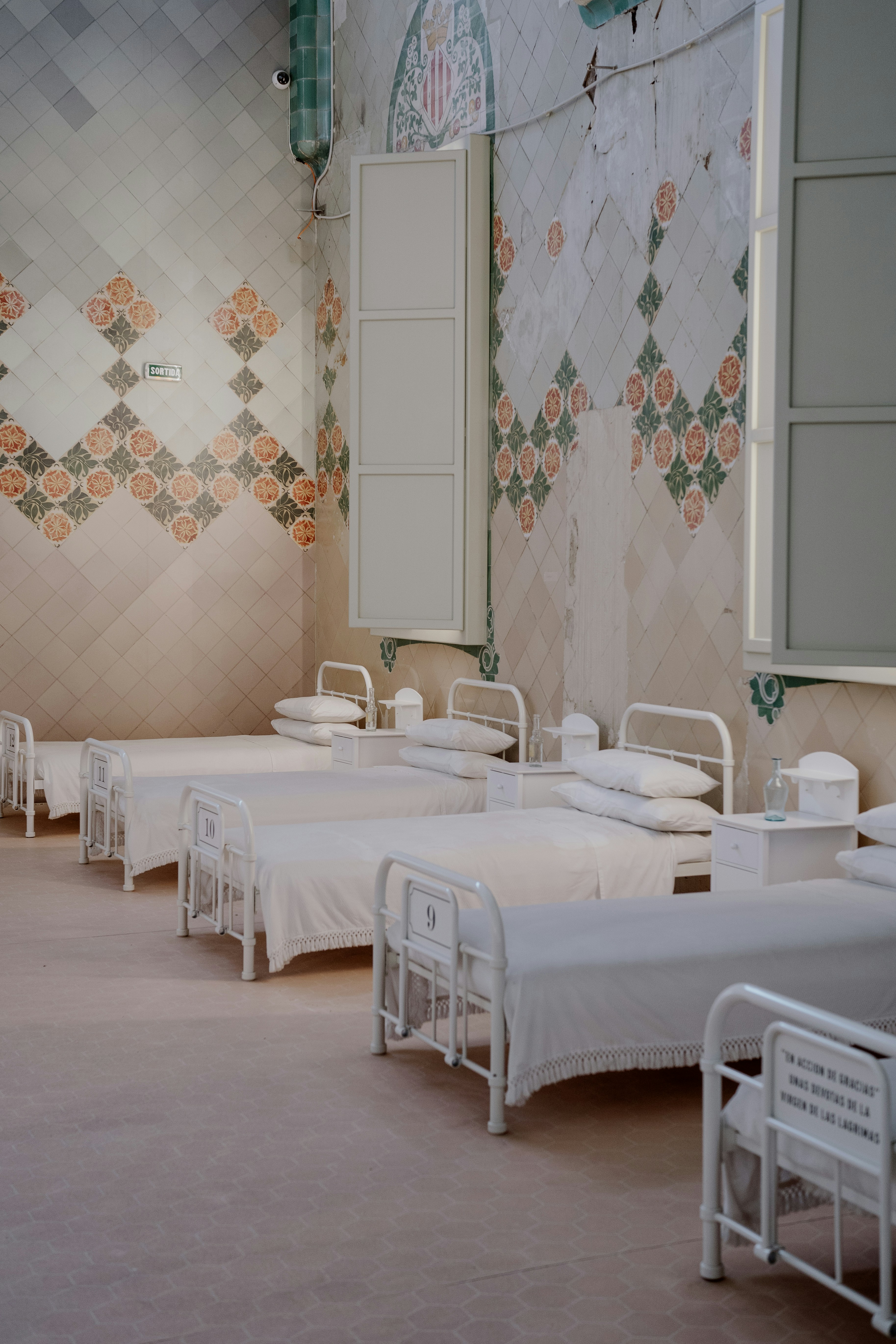 A row of beds in a room with tiled walls photo – Free Grey Image on ...