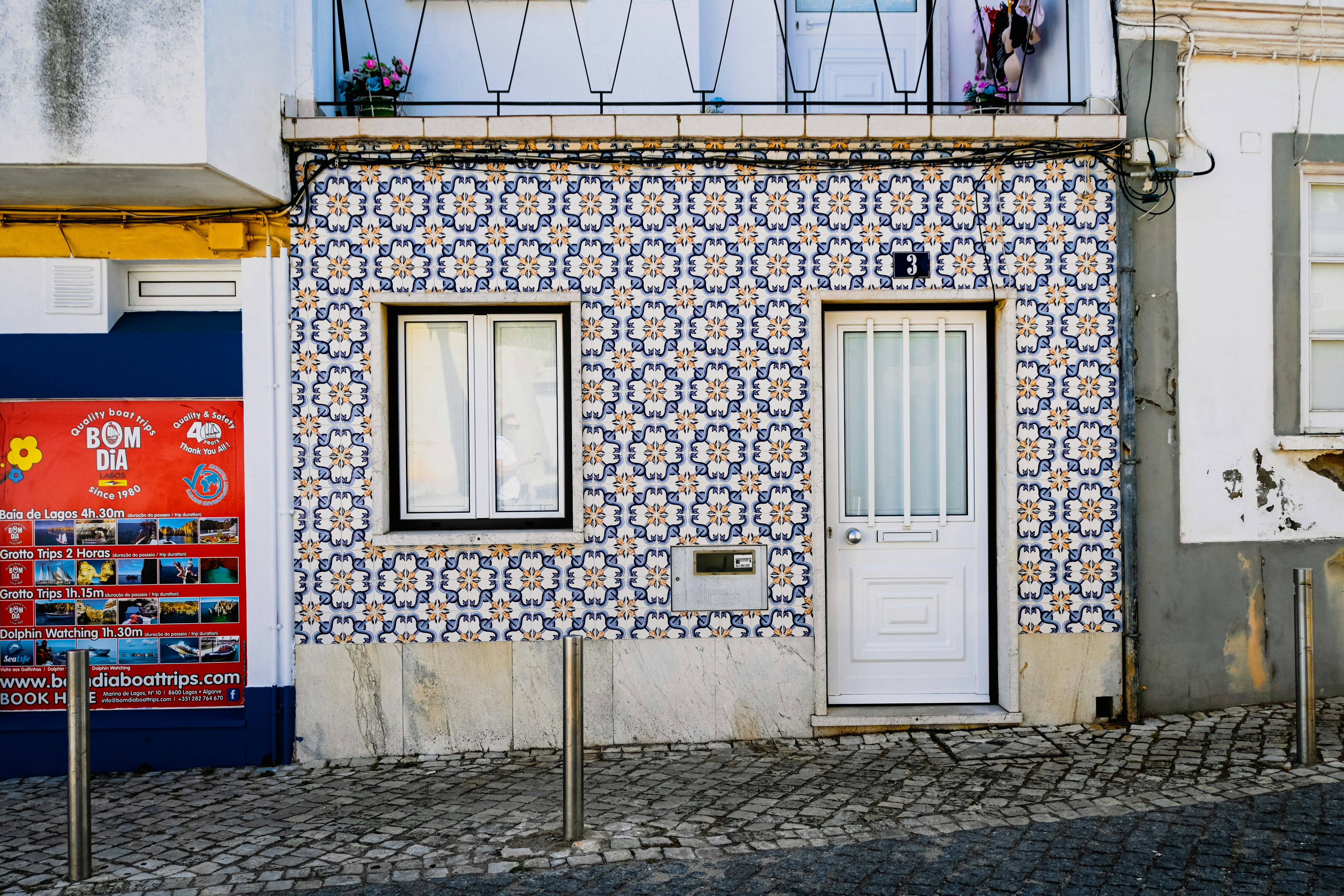 Doorway in a Mosaic Blue Tile Façade Along a Cobblestone Street