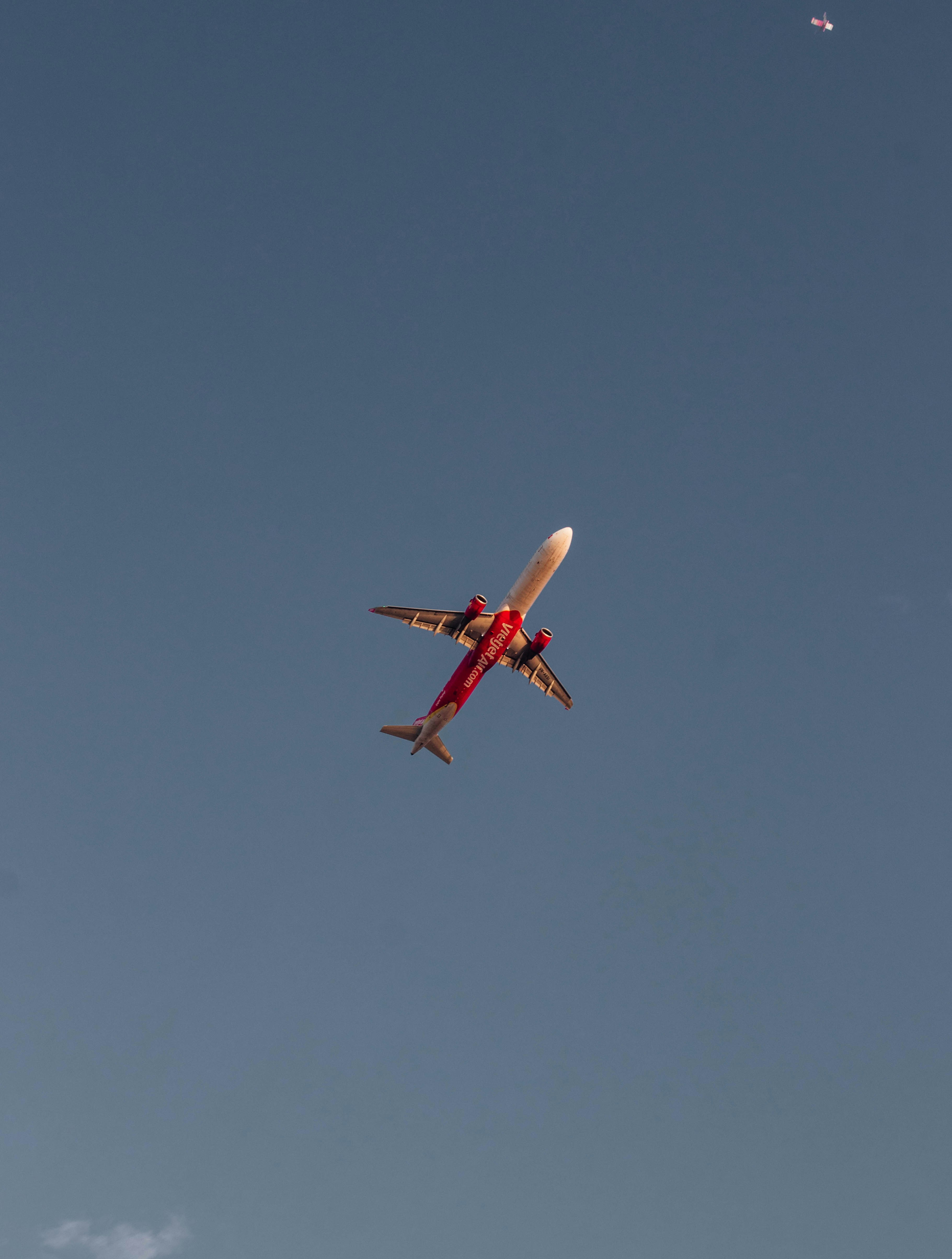 A red and white airplane flying in a blue sky photo – Free Singapore ...