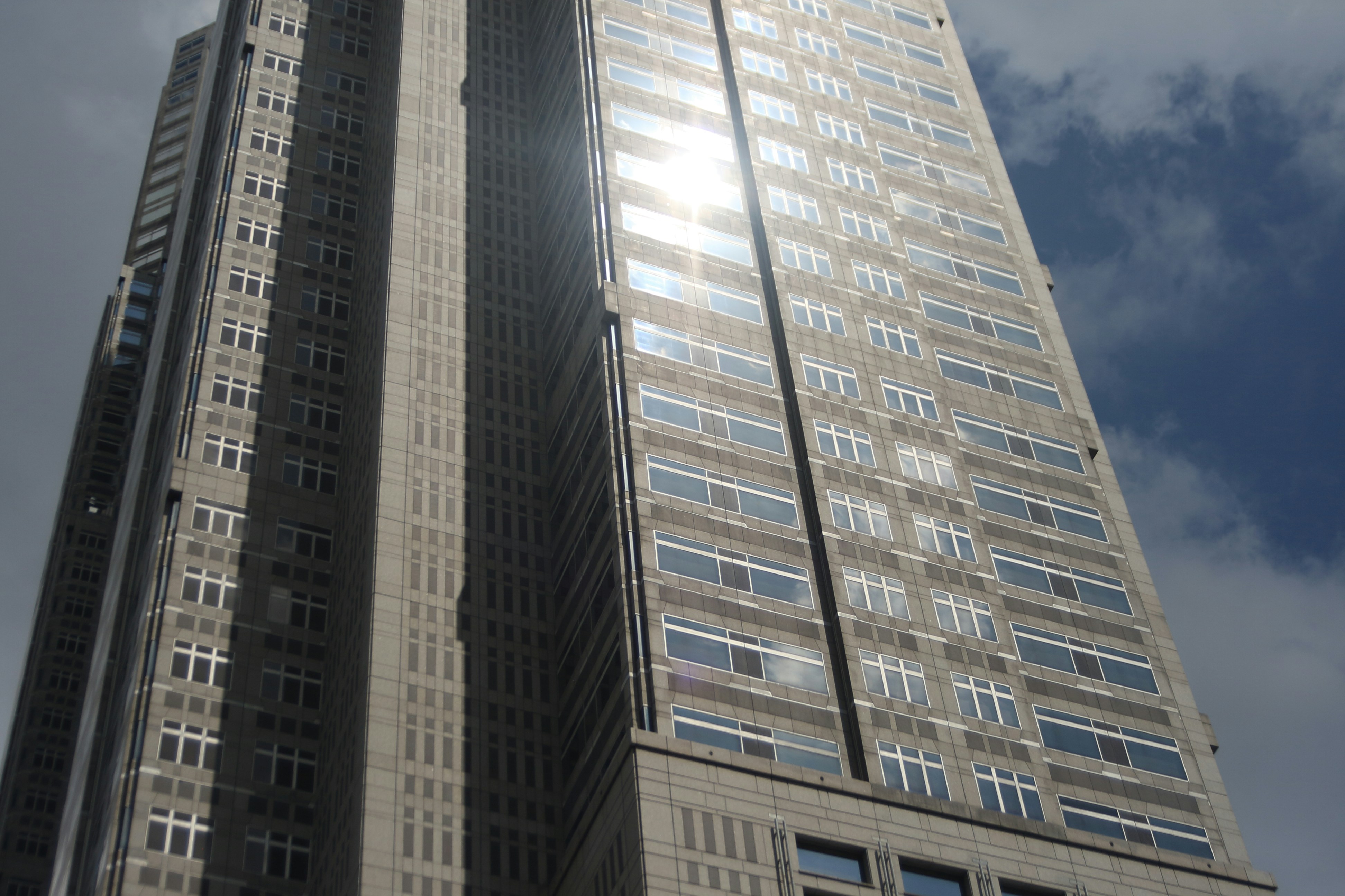 Sun-Glinted Glass: A Tower Silhouette Against a Bright Sky