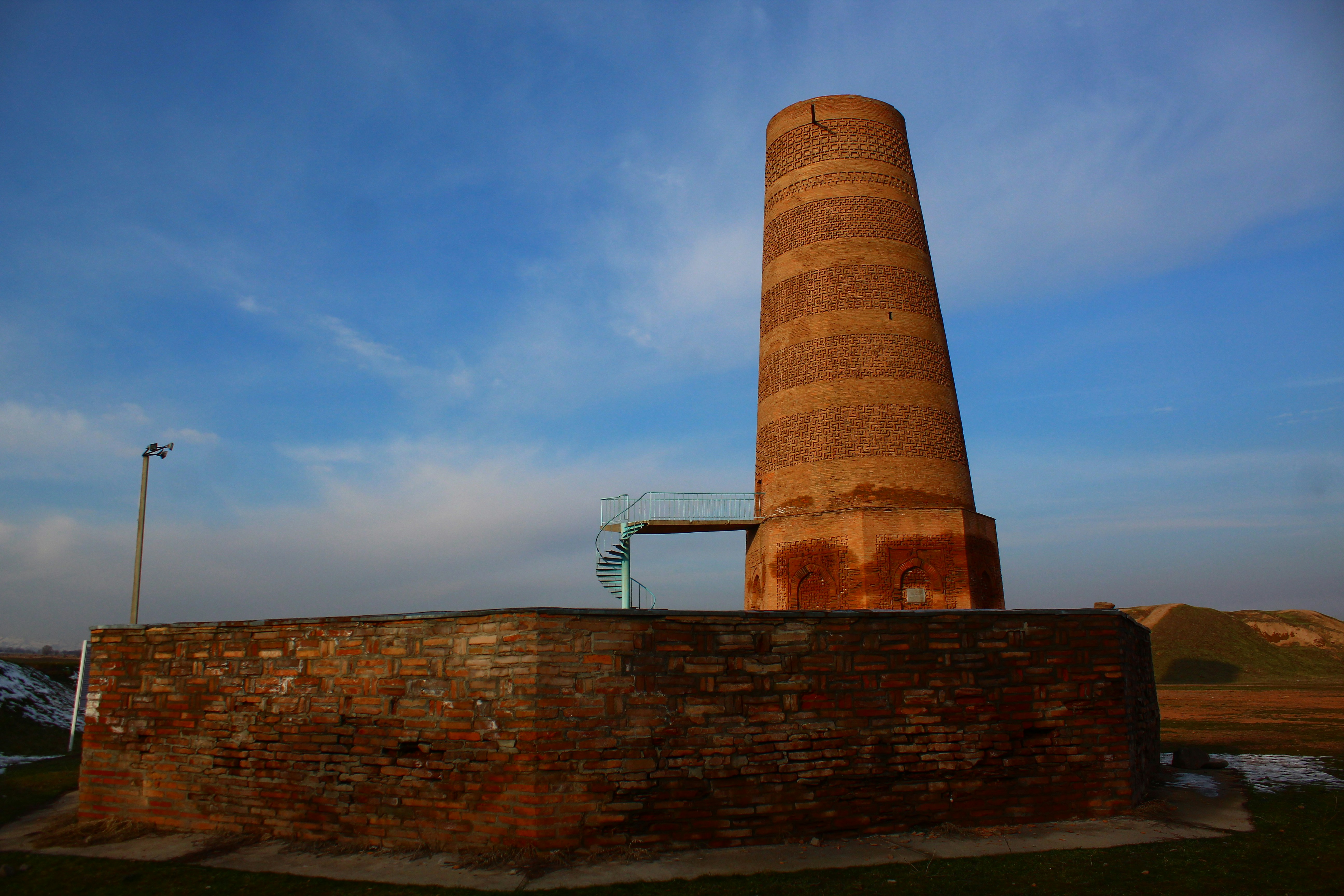 Brick Chimney on a Weathered Wall Under a Clear, Expansive Sky