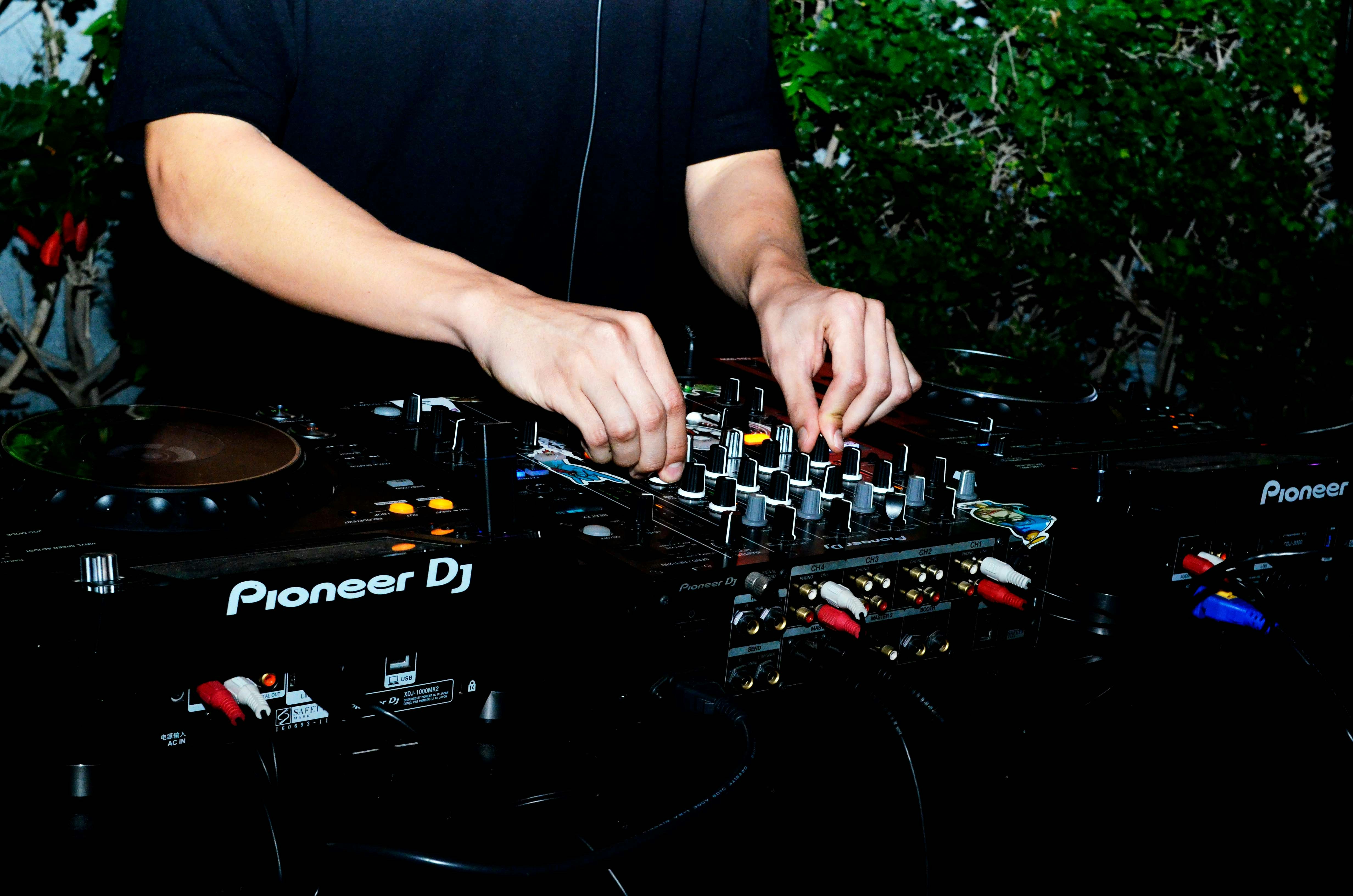 A dj mixing music in front of a bush photo – Free Human Image on Unsplash