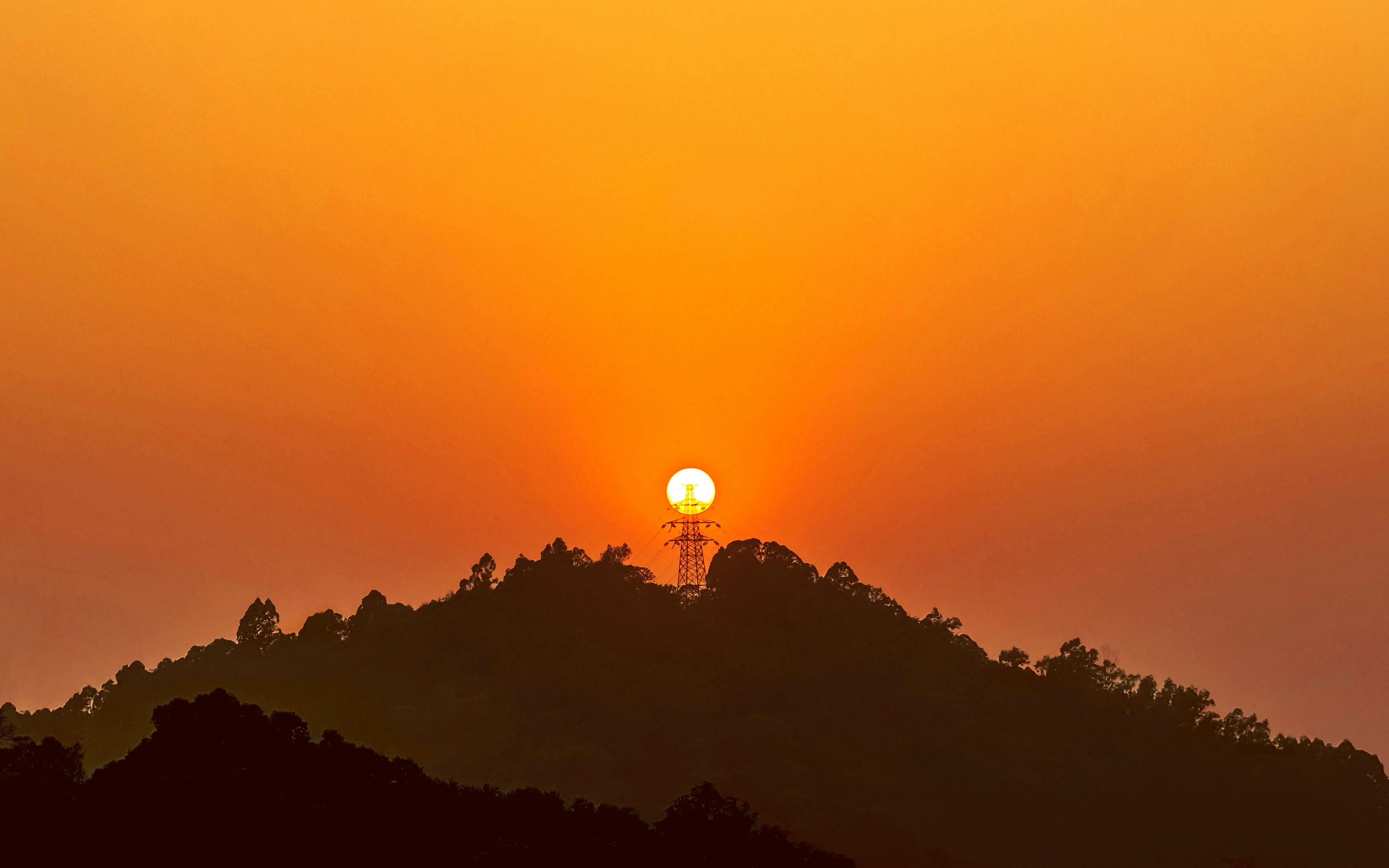 Molten Horizon: Sunset Silhouette on a Hilltop Antenna