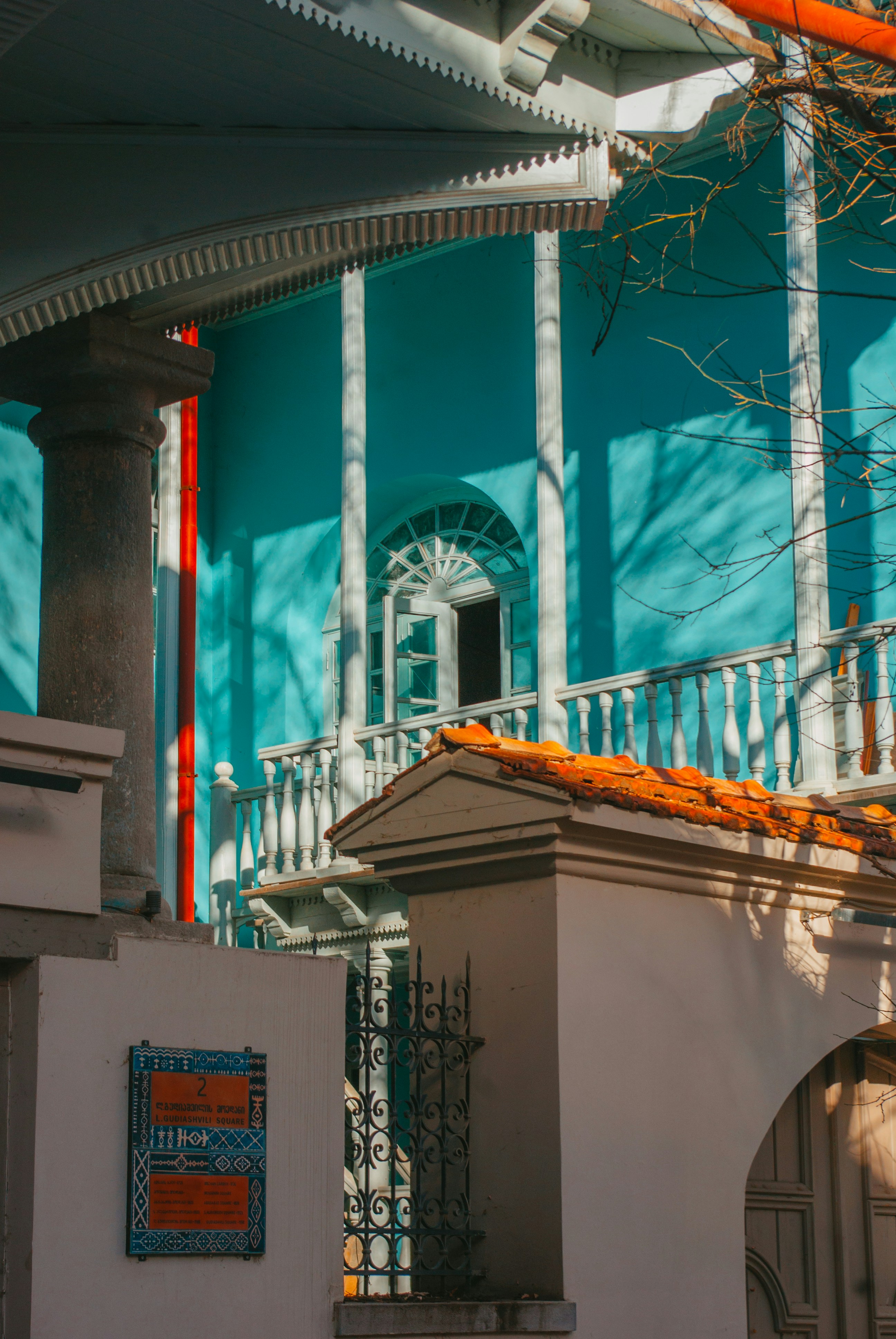a blue building with a white fence and a clock