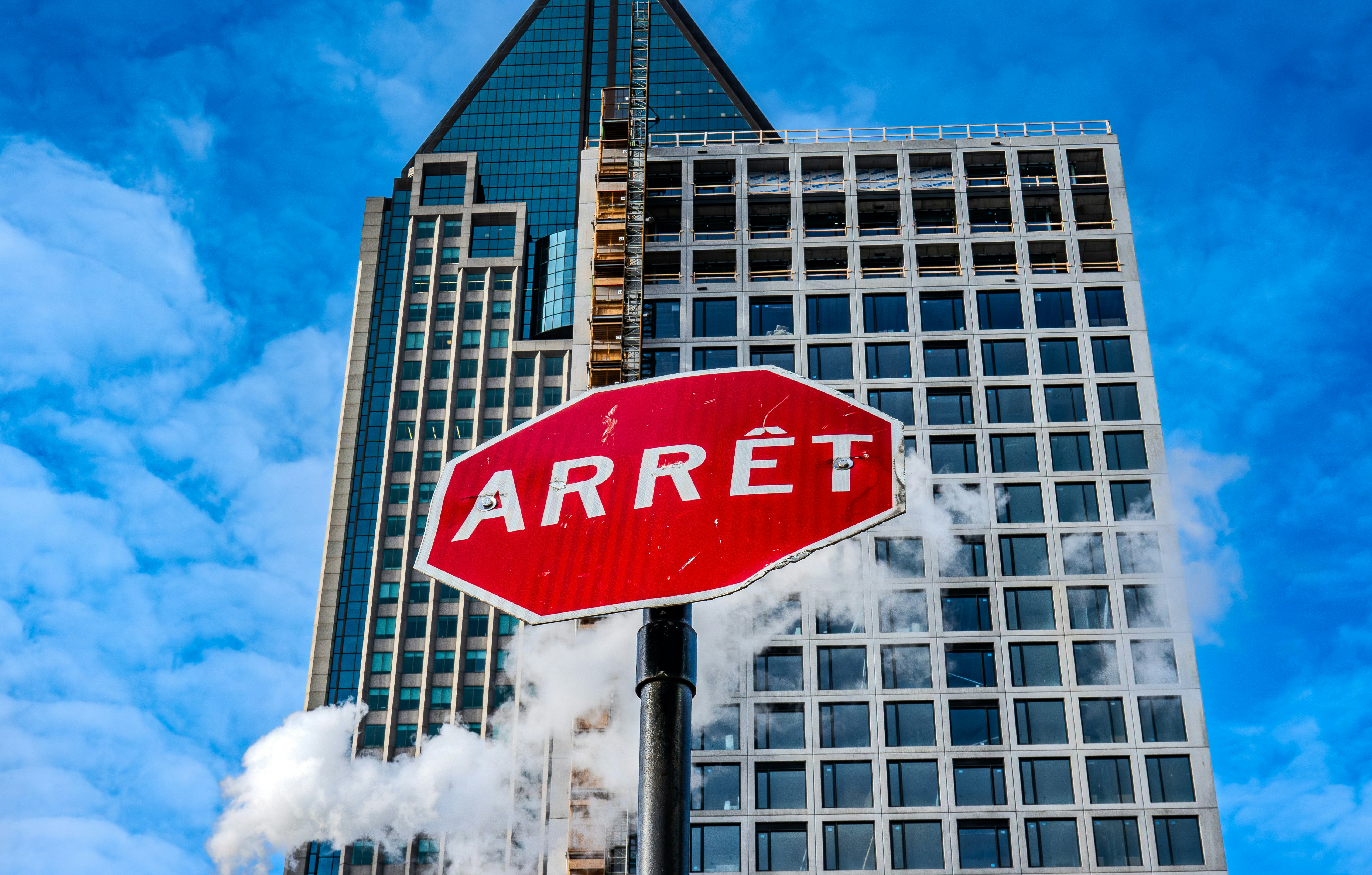 a (French) stop sign with a skyscraper in the background