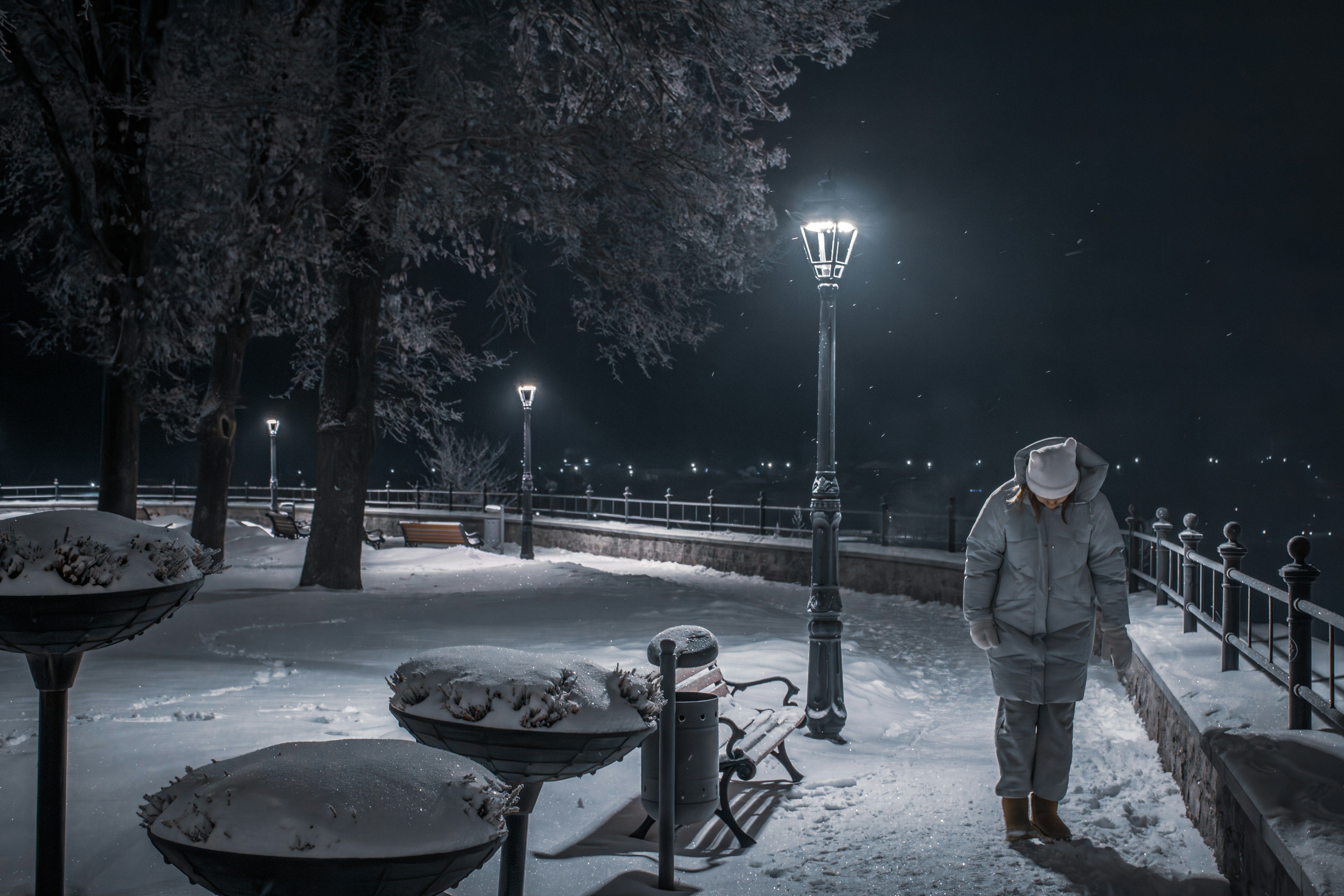 Silent Winter Promenade: A Lone Figure in the Snow by Lantern Light