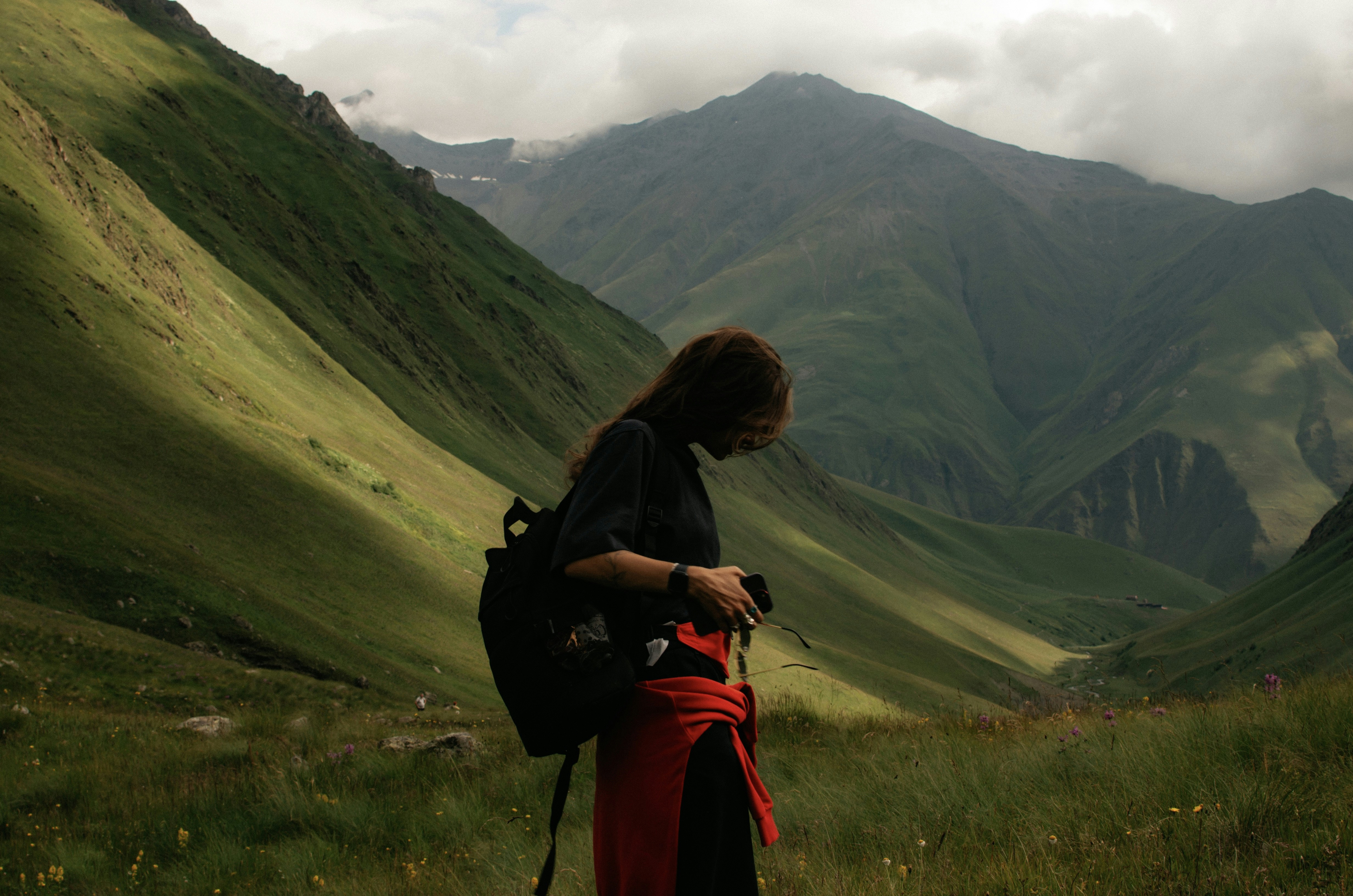 Alpine Frame: A Lone Photographer Pauses in a Verdant Valley