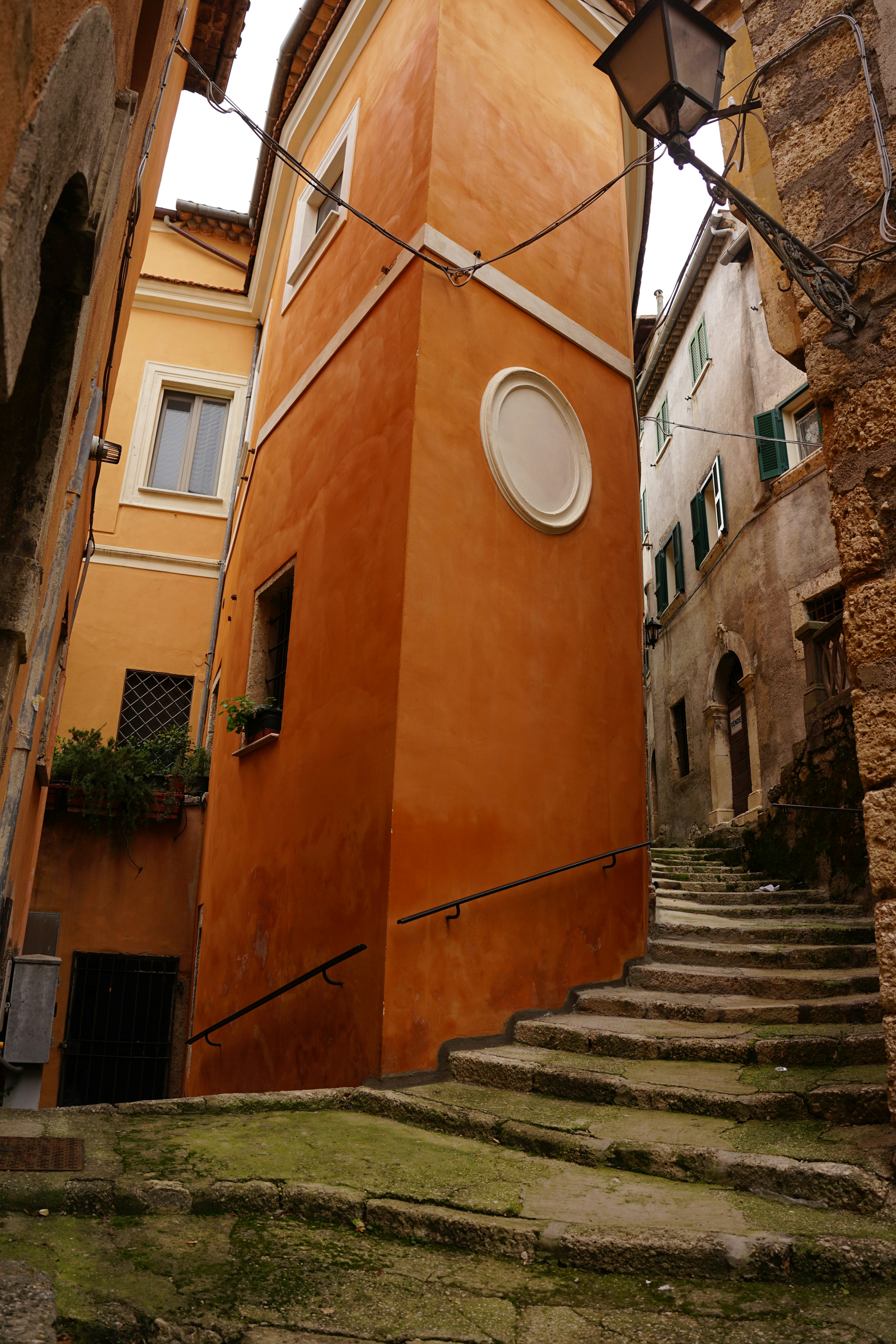 Orange-Walled Tower Framing a Winding Italian Staircase