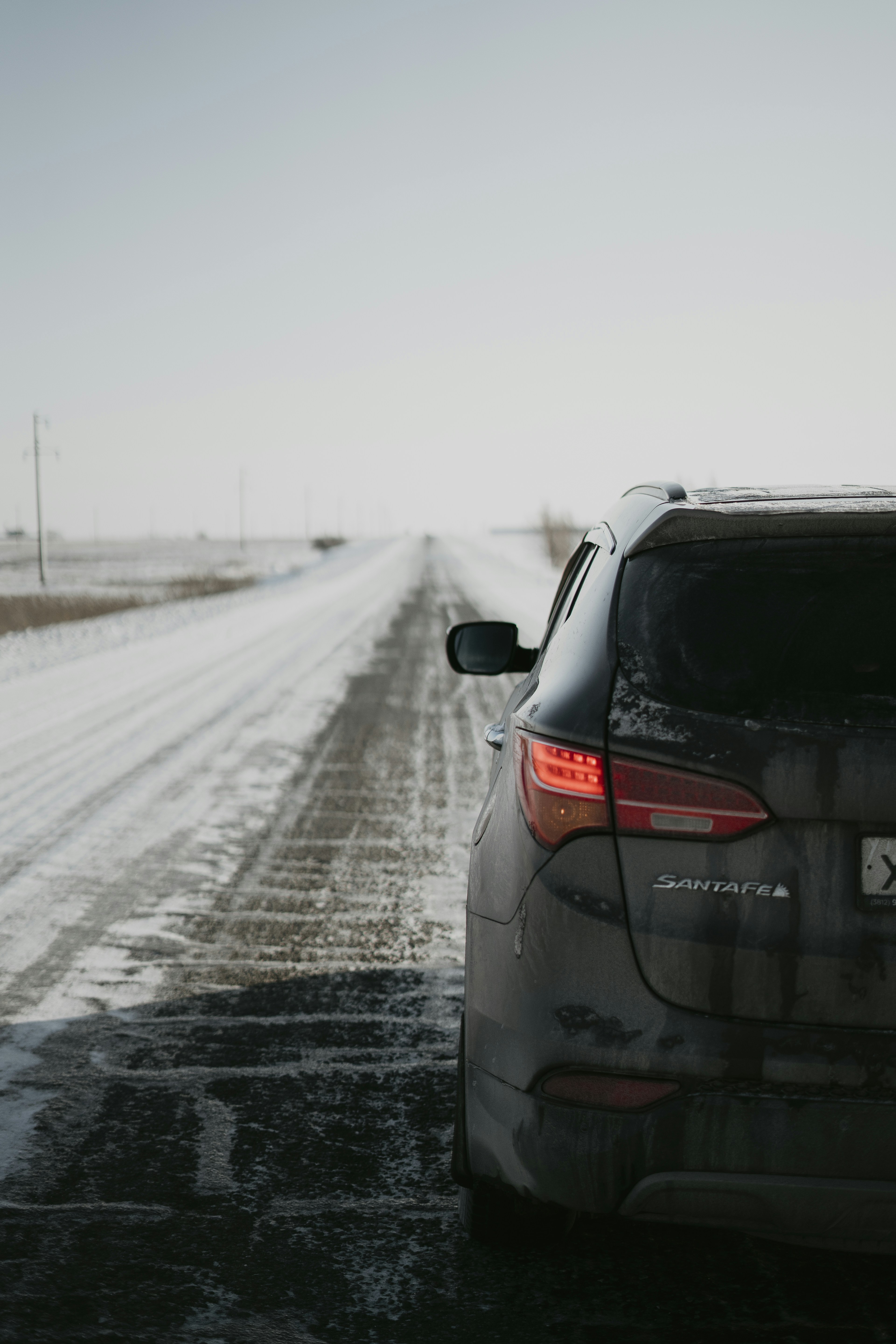 Snowbound Highway: The SUV's Red Tail Light in a Quiet Prairie Freeze