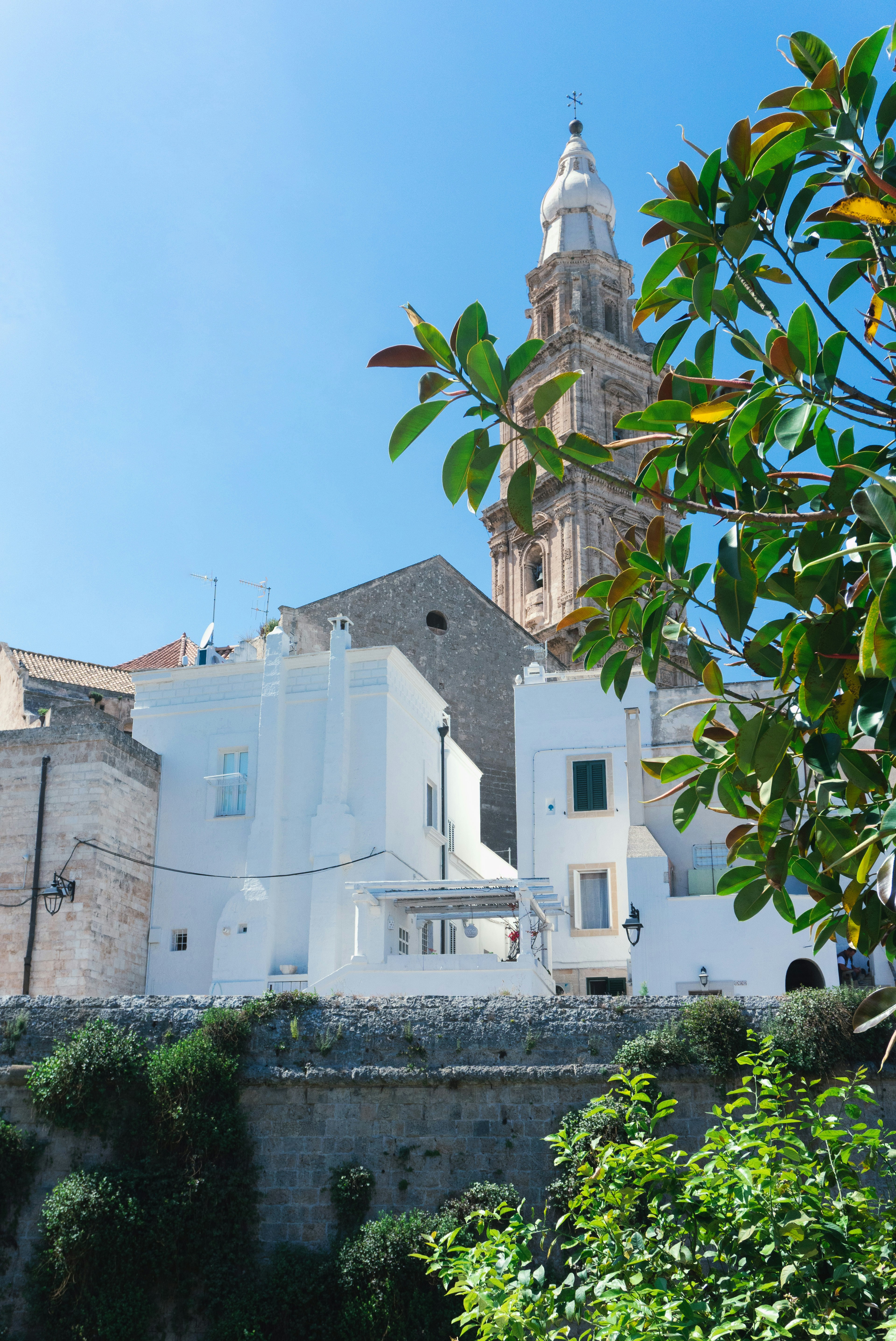 Aloft in Blue: Sunlit White-Walled Village and the Towered Spire