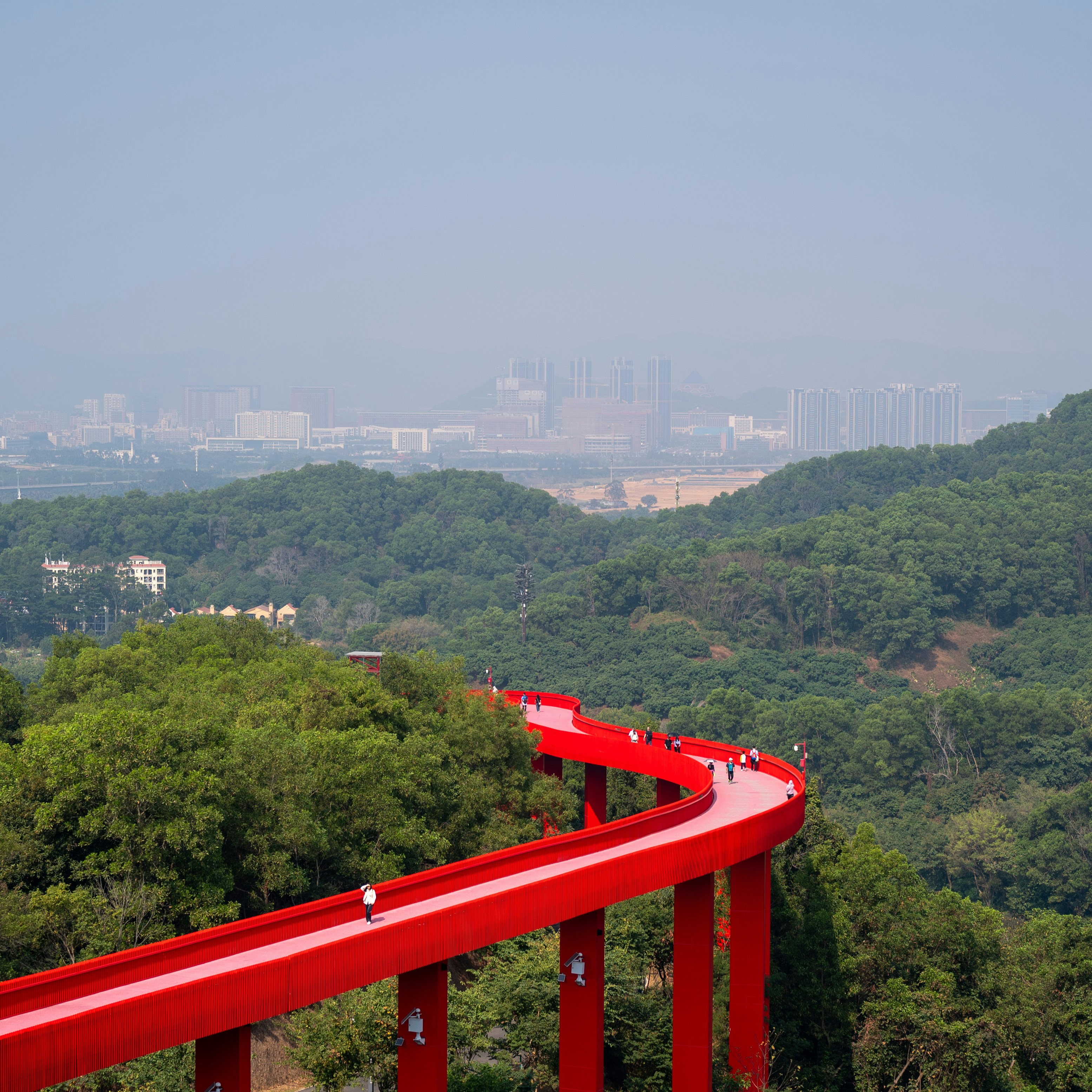 A very long red bridge over a large body of water photo – Free ...