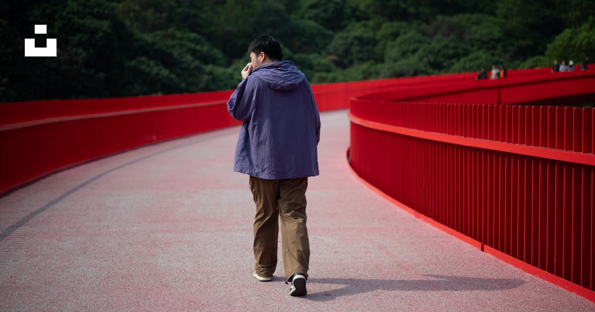 Foto Un Hombre Caminando A Través De Un Puente Rojo Hablando Por