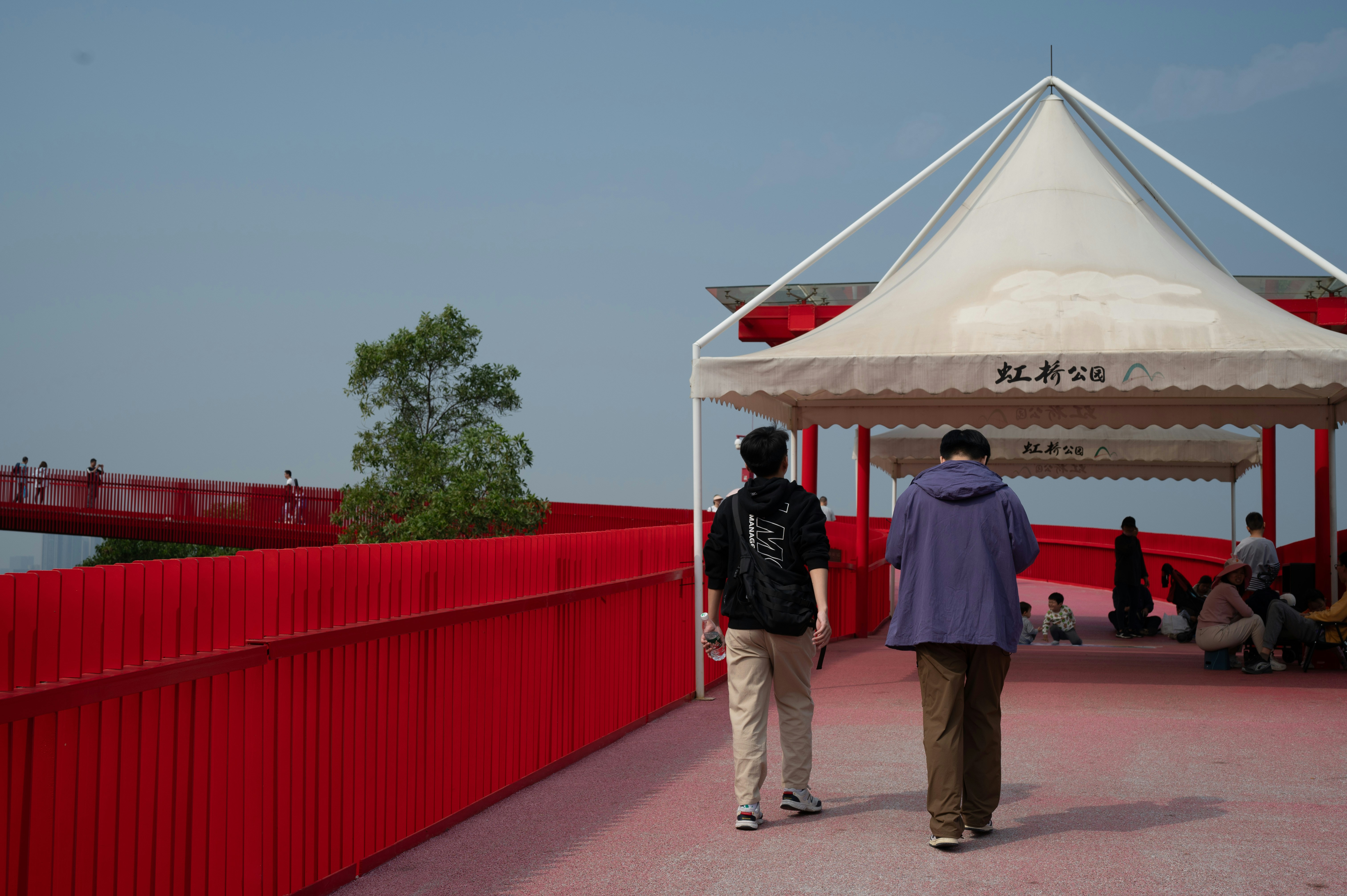 A couple of people walking across a bridge photo – Free Man Image on ...
