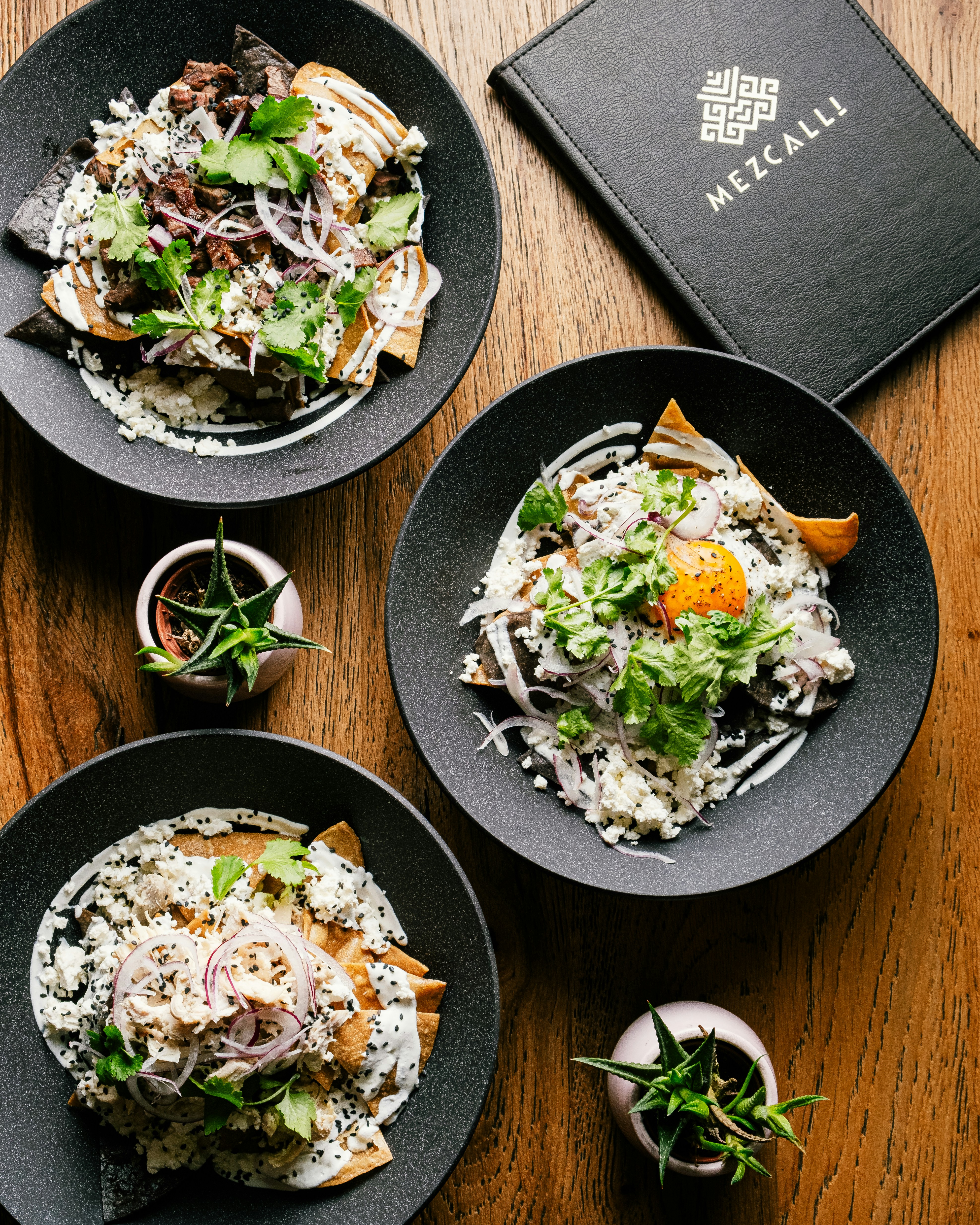 Triad of bowls: vibrant toppings crown hearty grains on a wooden spread
