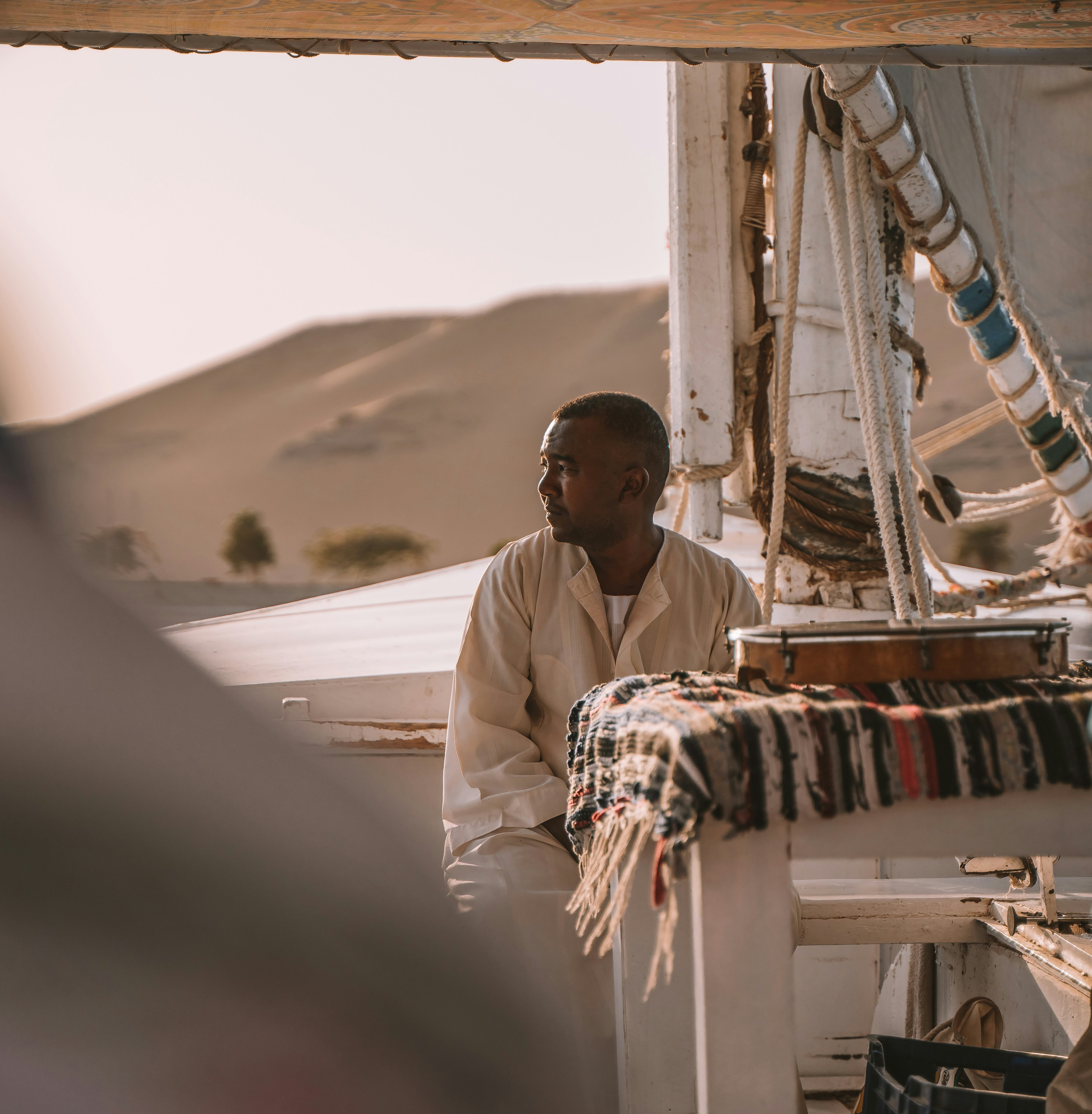 Portrait on a Quiet Deck: A Sailor at Dusk with Dunes in the Distance